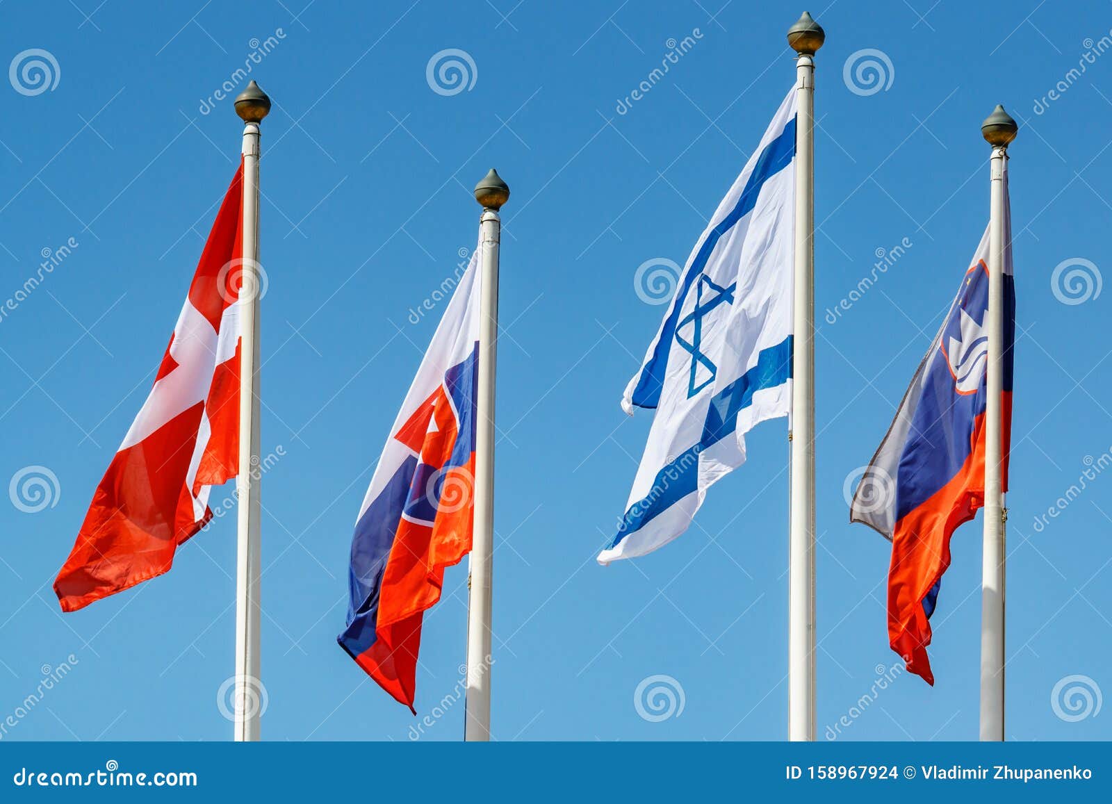 Waving Flags of Different Countries on Flagpoles on a Blue Sky ...