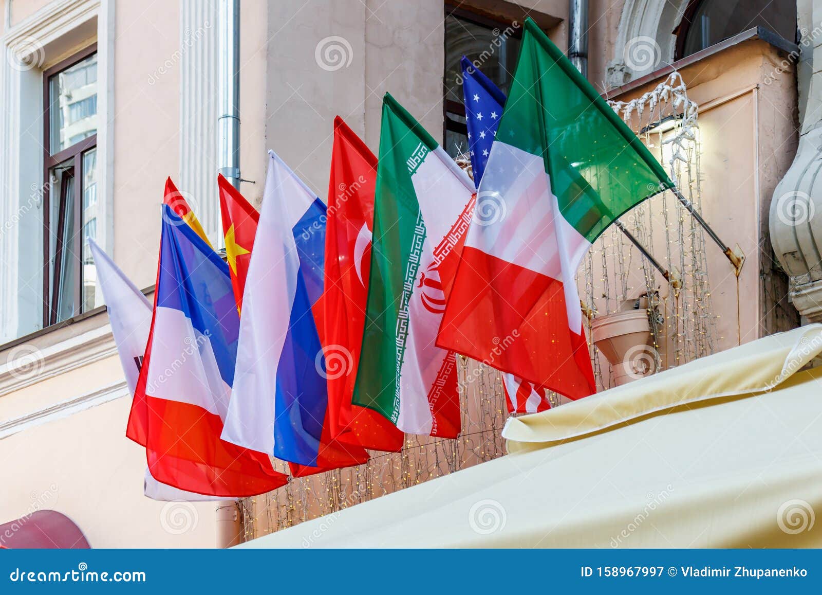 Waving Flags of Different Countries in a Row on the Wall in Sunlight ...