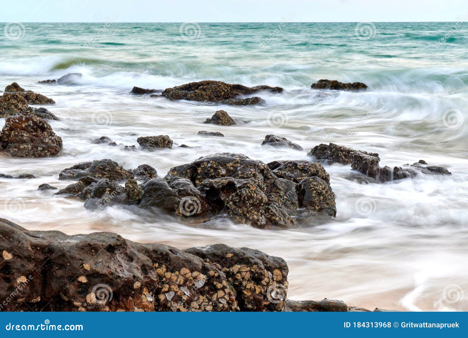 Wavy Sea with Rocks Near a Beach Stock Photo - Image of ocean, blue ...