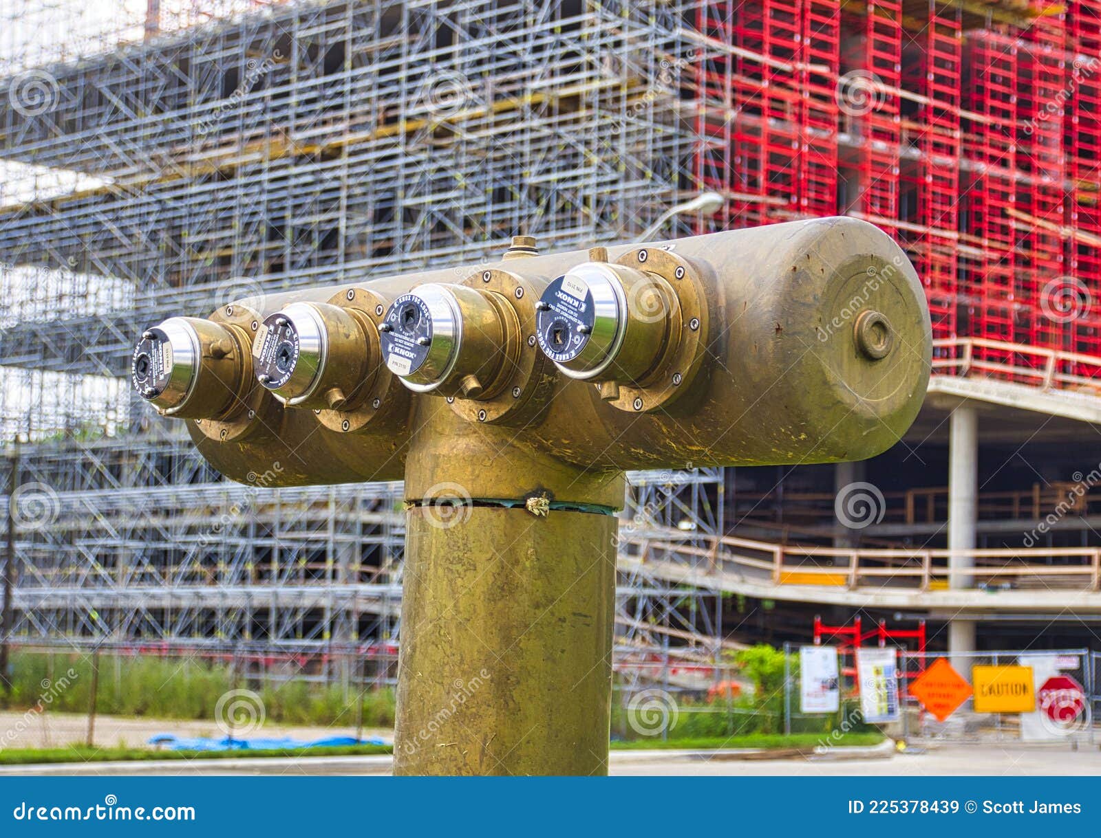 4 Way Brass Fire Hydrant with Construction Site in Background Stock ...
