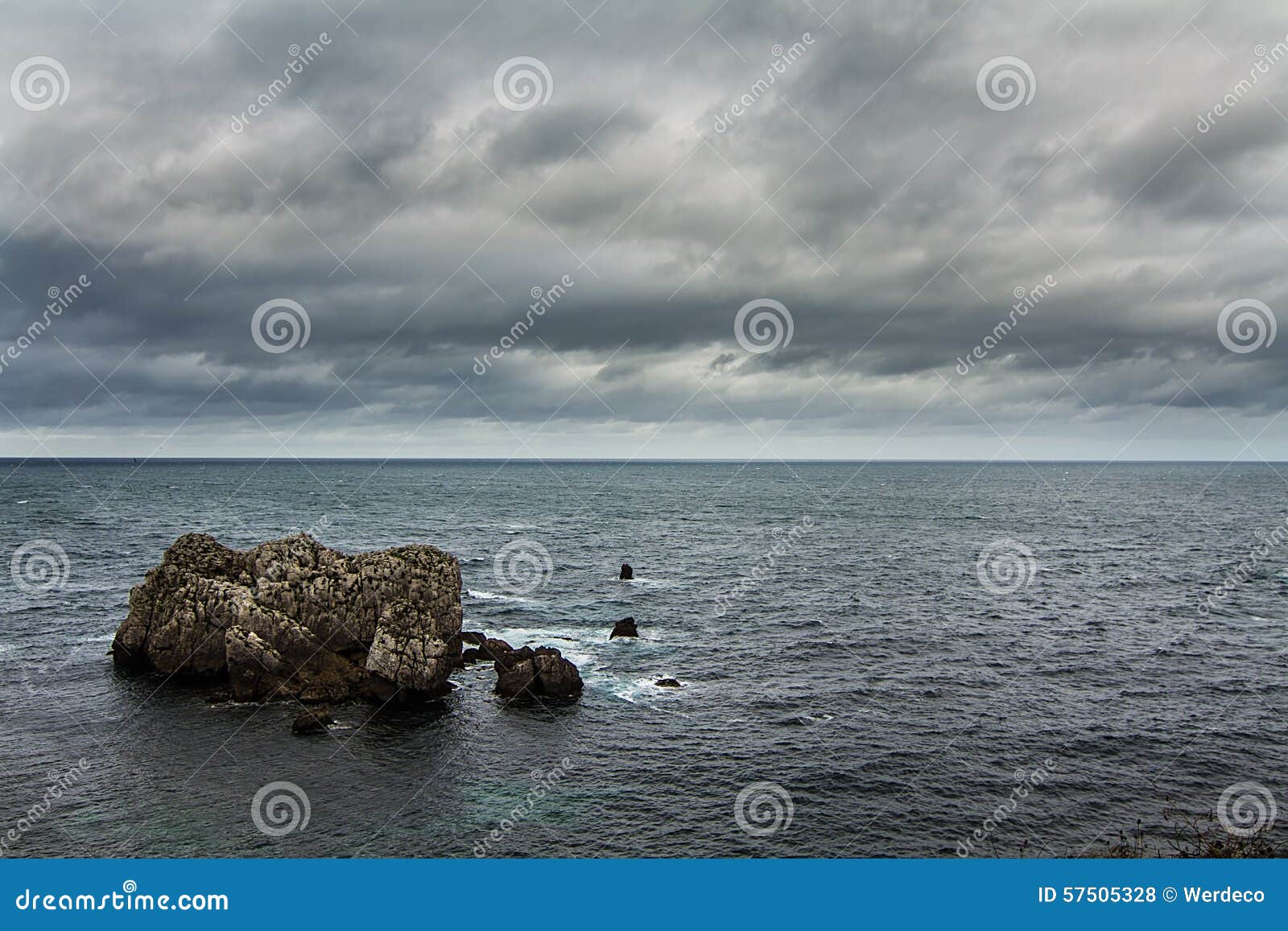 Weathered rock in ocean stock photo. Image of clouds - 57505328