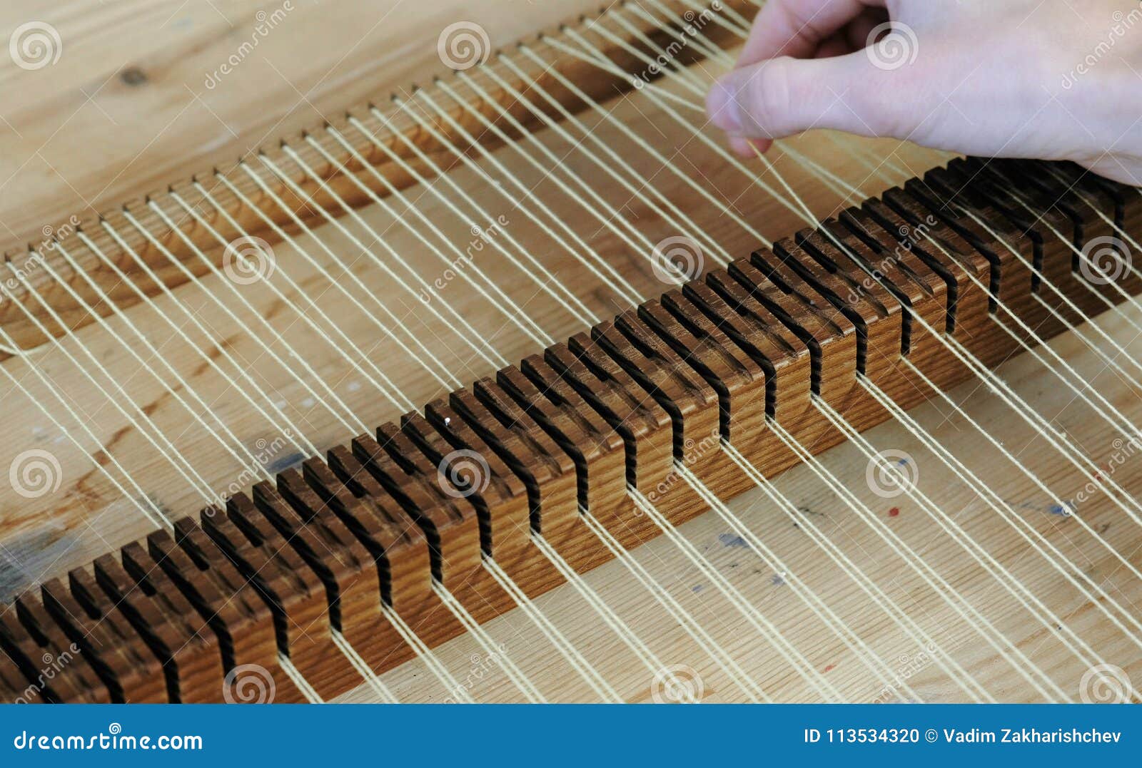 Weaving on a Loom Frame. Closeup Woman`s Hand Puts the Thread in the ...