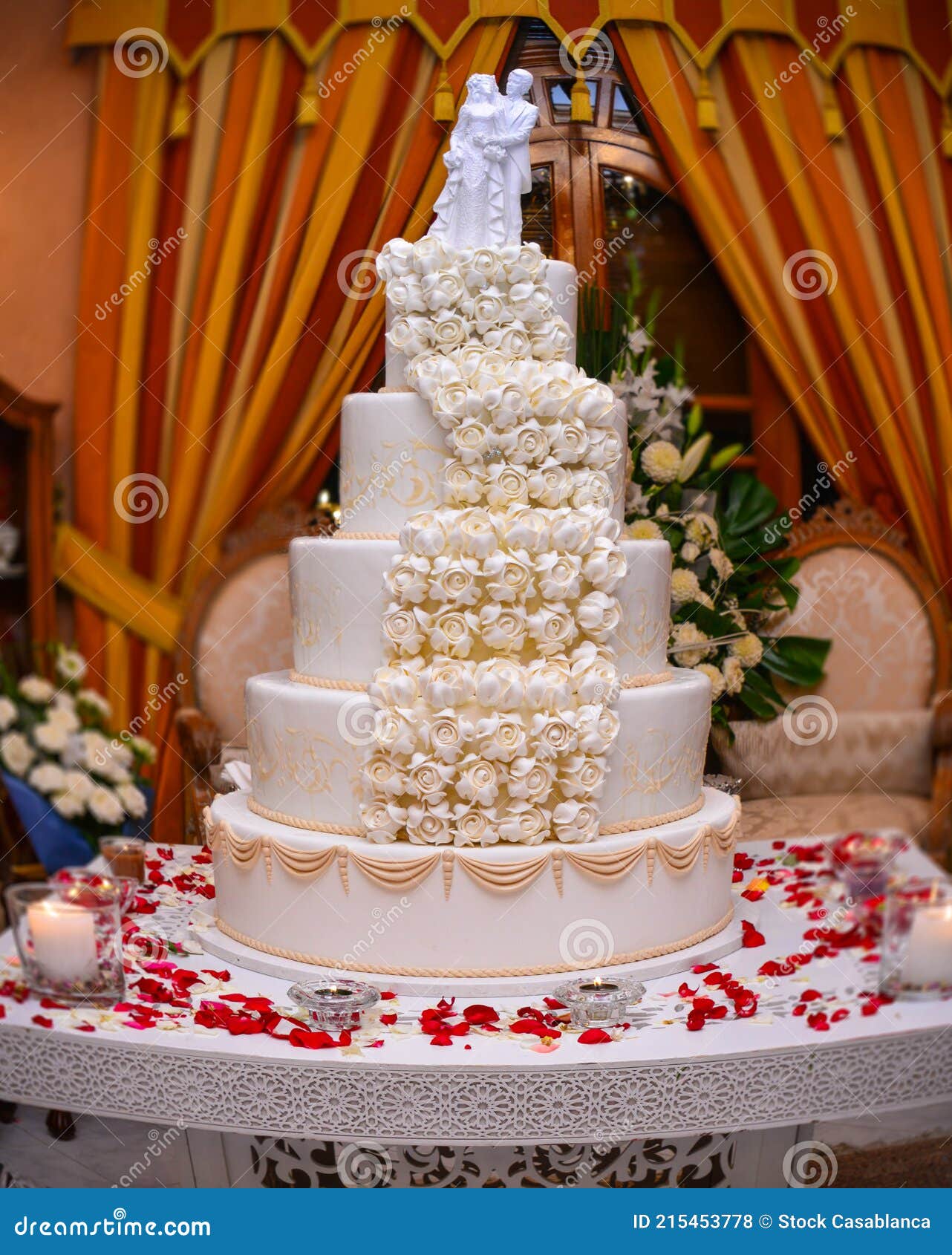 Wedding Cake On A White Table Decorated With Red Roses. Wedding Statues ...