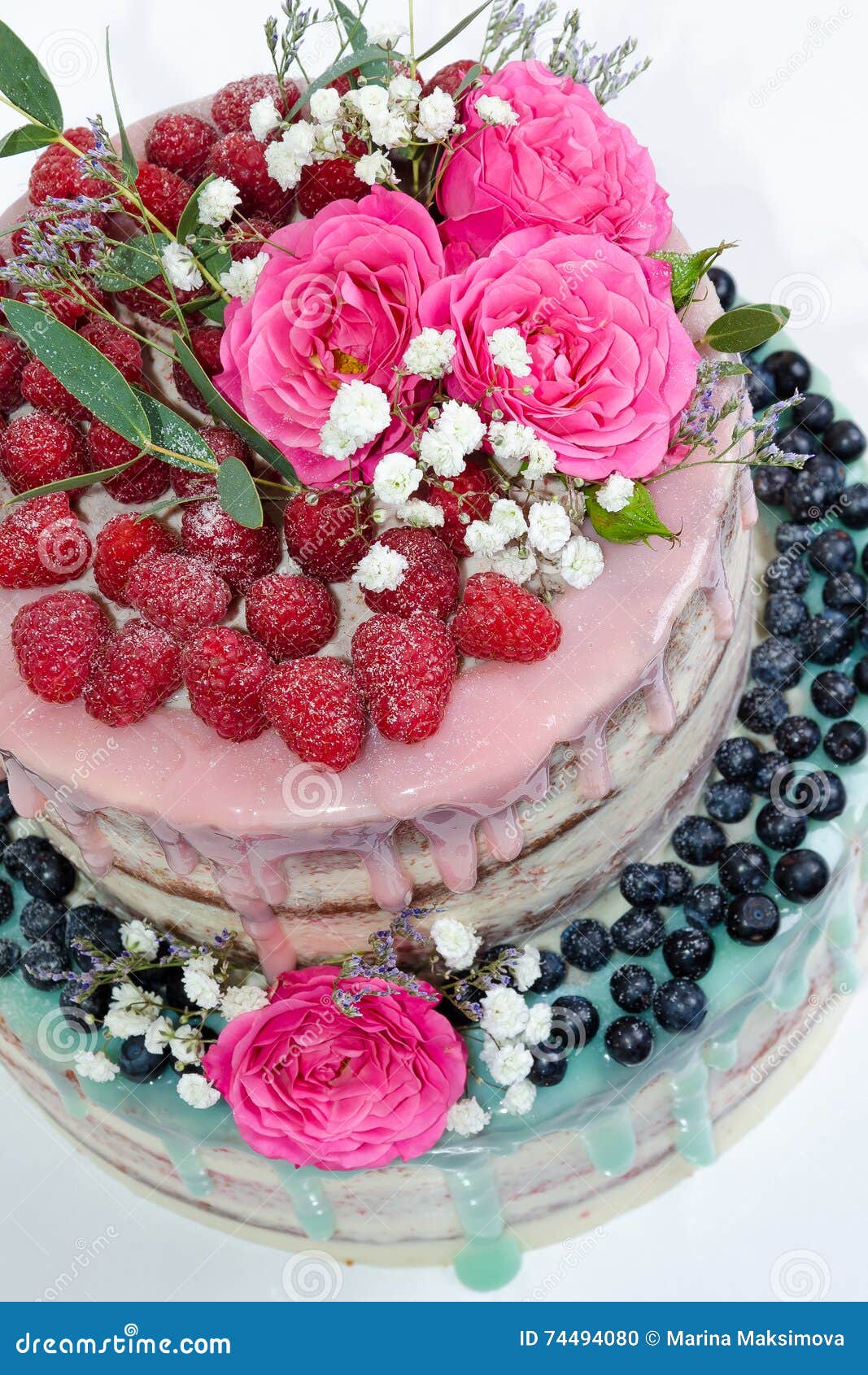 A Wedding Color Drip Cake with Roses, Blueberries and Raspberries Stock ...