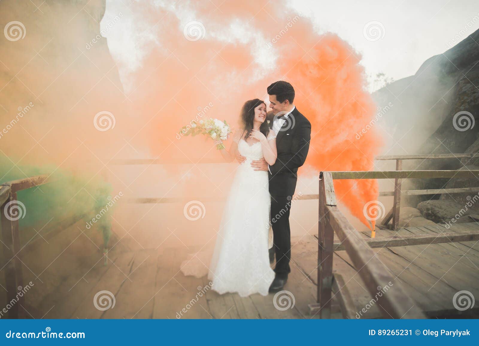 Wedding Couple Posing Near Rocks with Colored Smoke Behind Them Stock ...