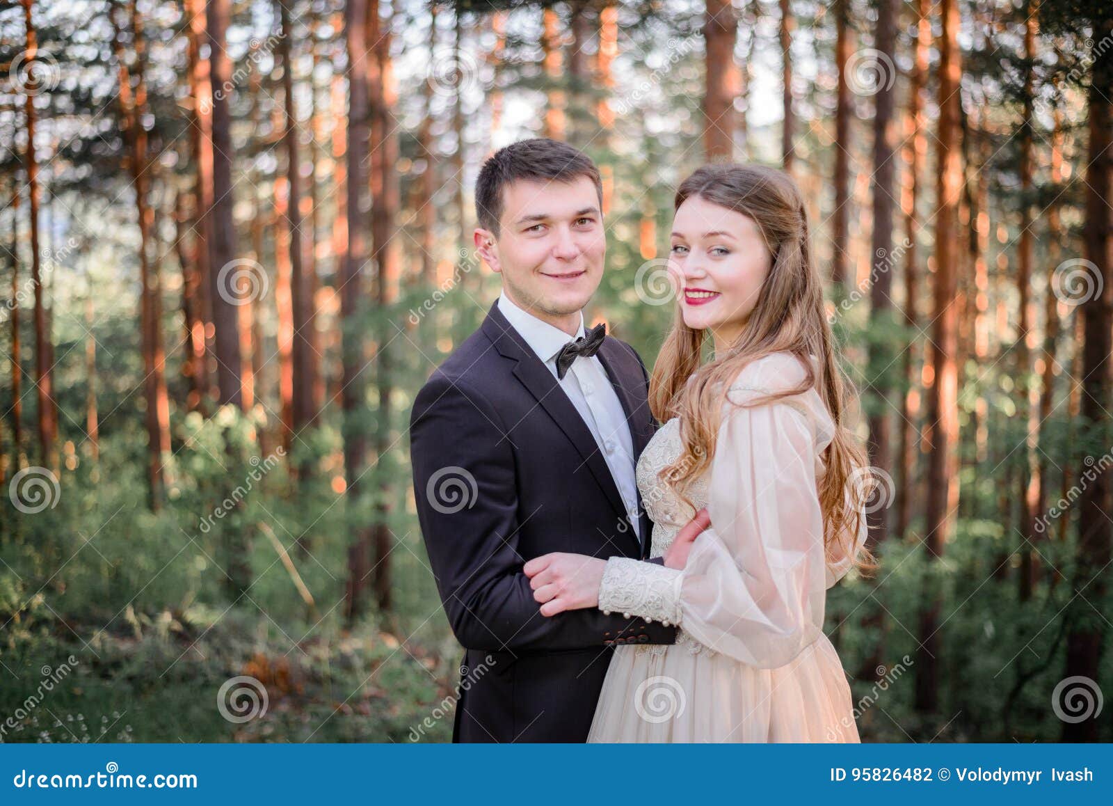 Couple Stands In The Forest Together. Attractive Girl Hugging Her ...