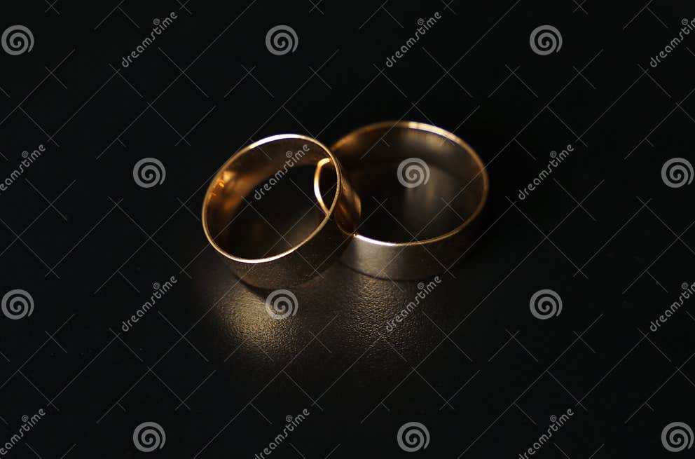 Wedding Rings on a Black Background in the Rays of Light. Stock Photo ...