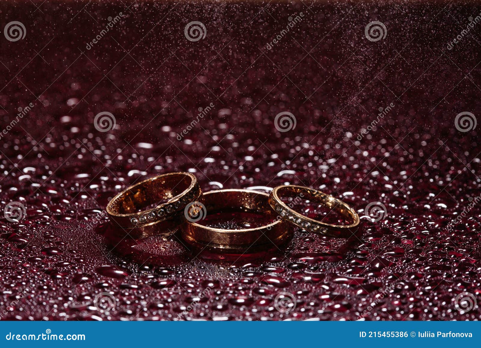 Wedding Rings on Dark Water Surface Shining with Light. Rain, Water ...