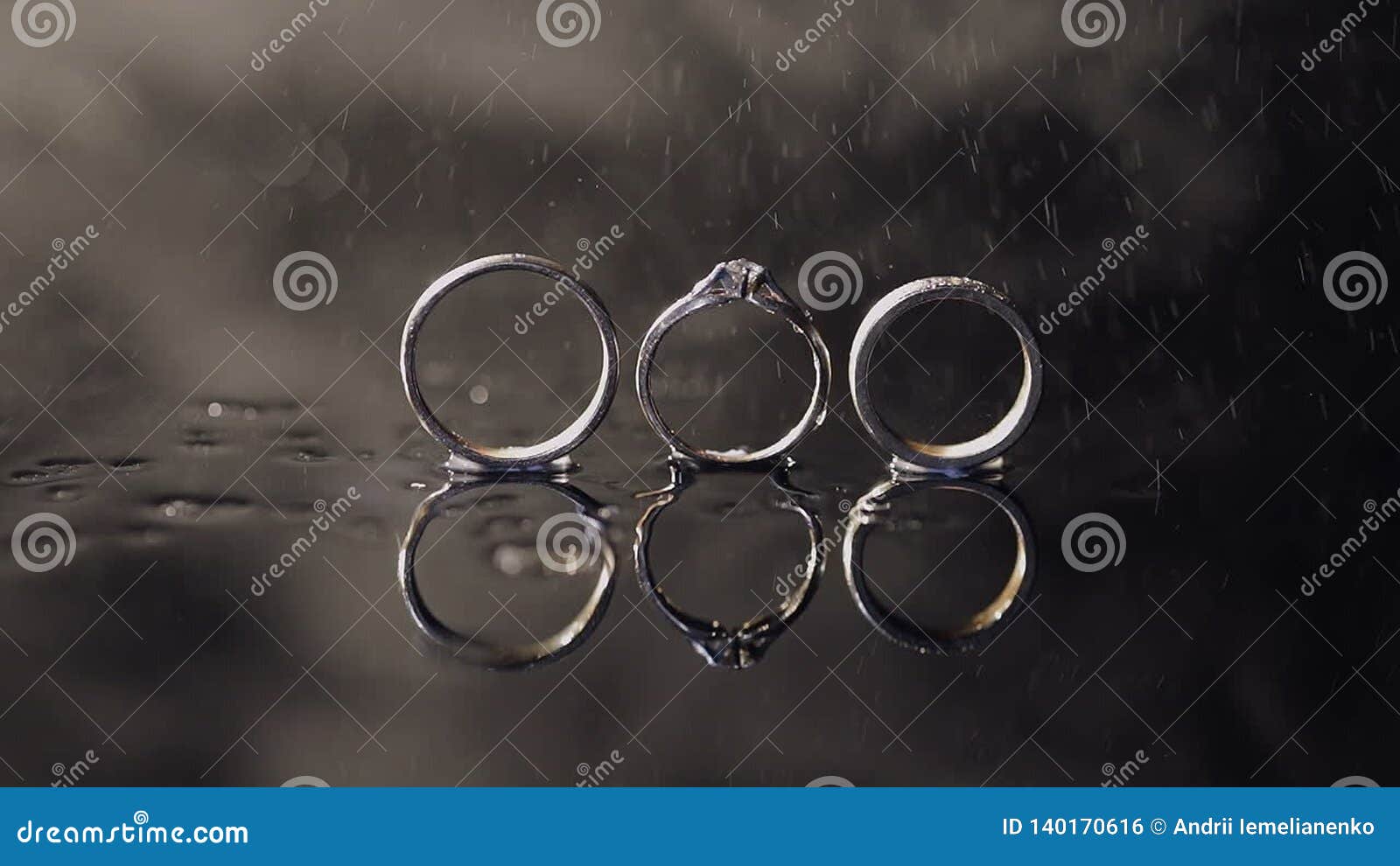 Wedding Rings and Engagement Ring Lying on Dark Water Surface Shining ...