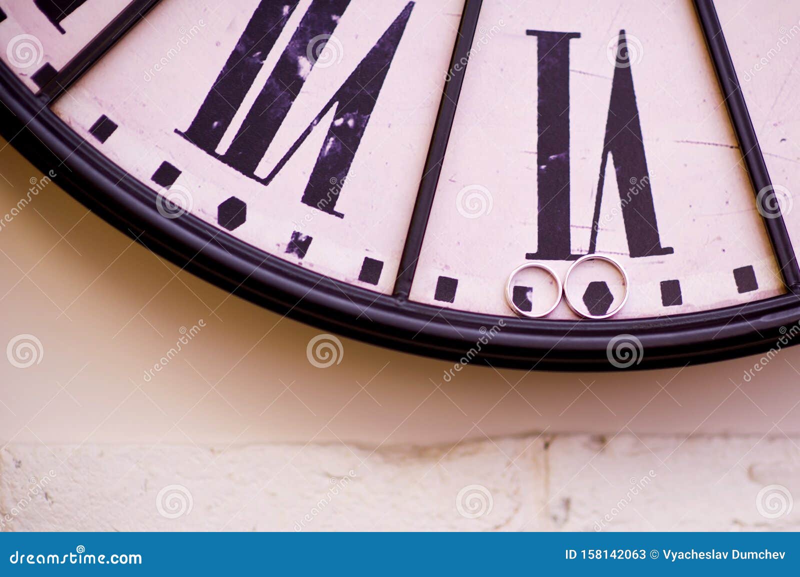 Two Wedding Rings Lie on the Dial of a Wall Clock Stock Image - Image ...