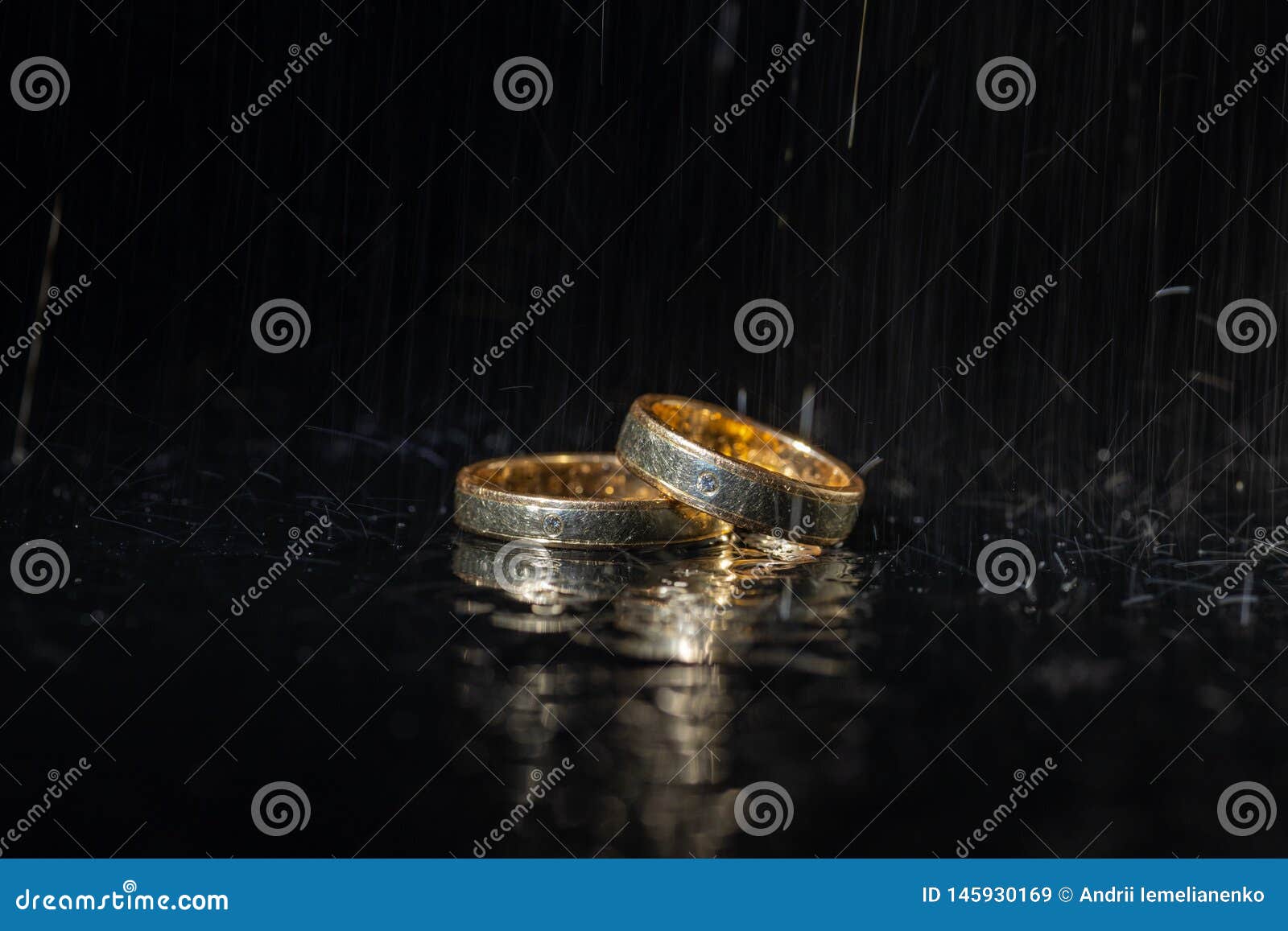Wedding Rings Lying on Dark Surface Shining with Light. Water Splashes ...