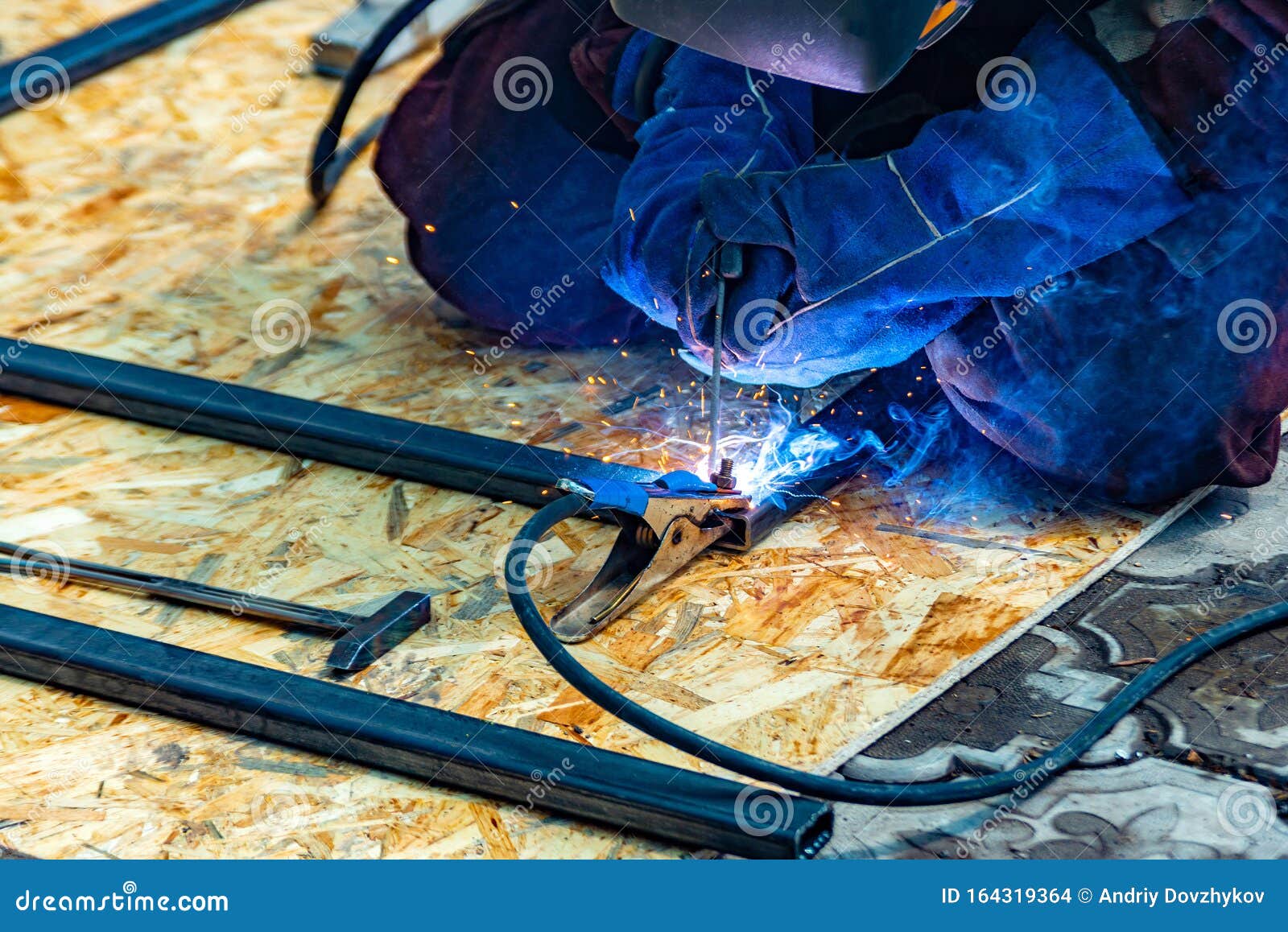 A Welder Assembles A Frame From A Metal Structure By Connecting It With ...