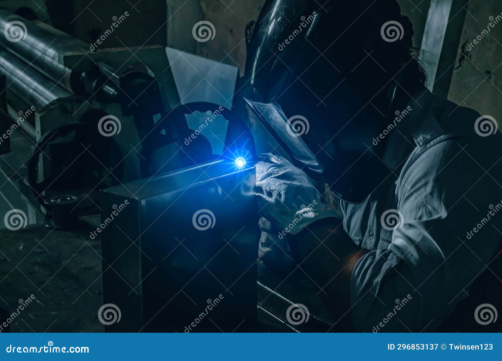 Welder in a Protective Mask Welds a Metal Box in a Locksmith S Workshop ...