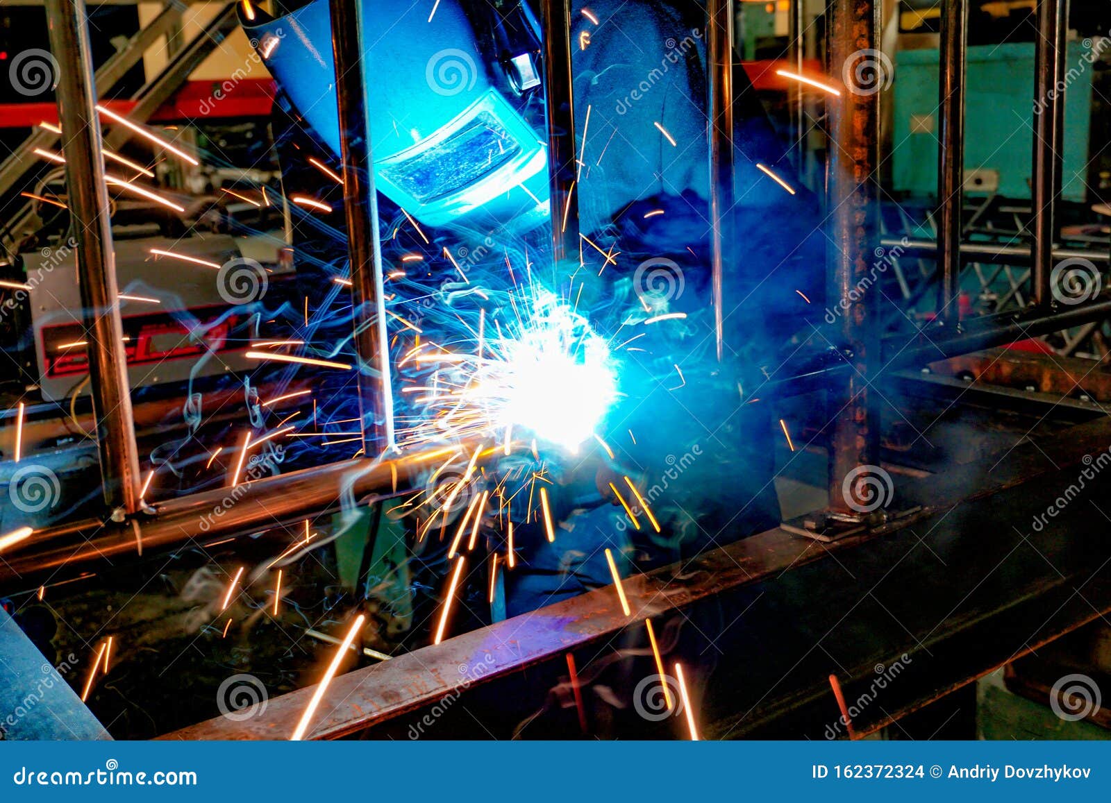 A Welder at Work in a Workshop Produces Metal Structures. Sparks from ...