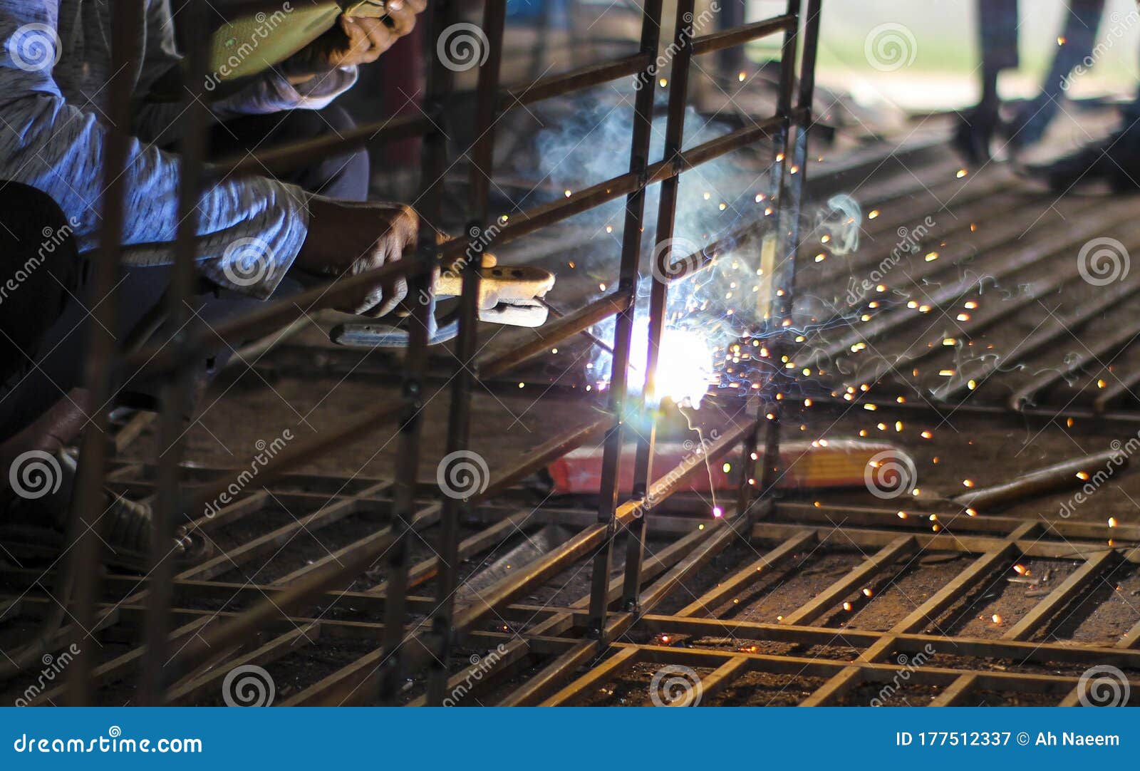 A Welder at Work in a Workshop Produces Metal Structures. Sparks from ...