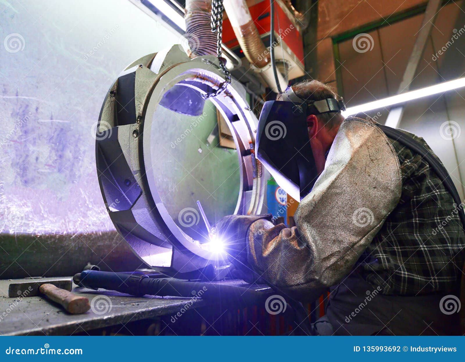 Welder at a Workplace in Metal Construction Working on a Workpiece Made ...