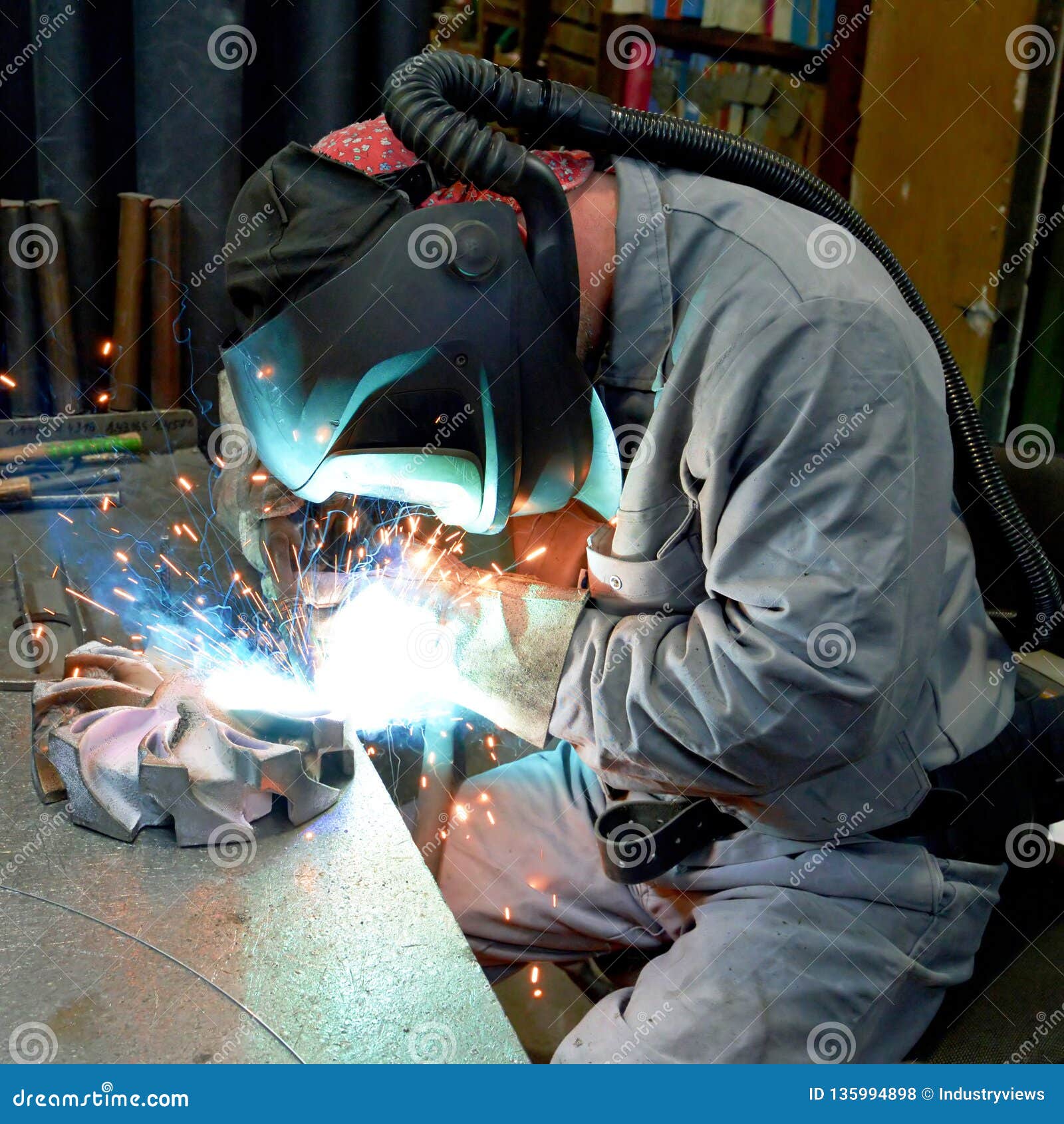 Welder at a Workplace in Metal Construction Working on a Workpiece Made ...