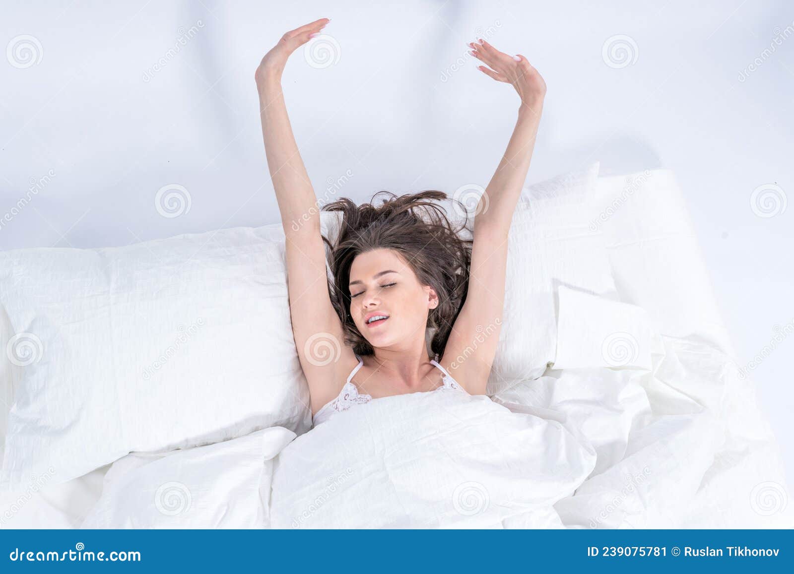 Wellness Concept. a Young Beautiful Brunette Woman Wakes Up in Her Bed ... Wellness Concept. a Young Beautiful Brunette Woman Wakes Up in Her Bed ...