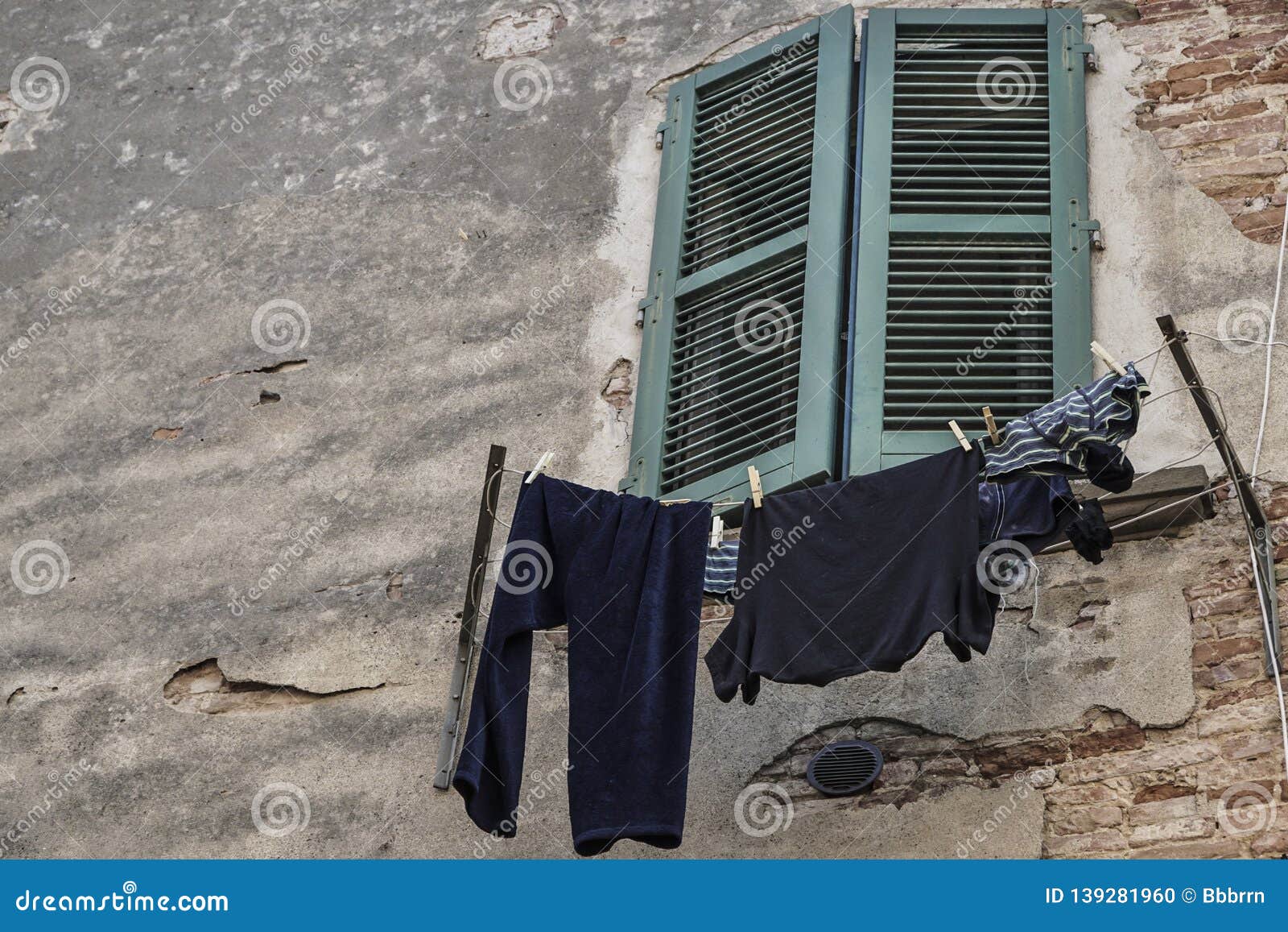 Clothes Hanged by Green Window Blind of a Building Stock Photo - Image ...