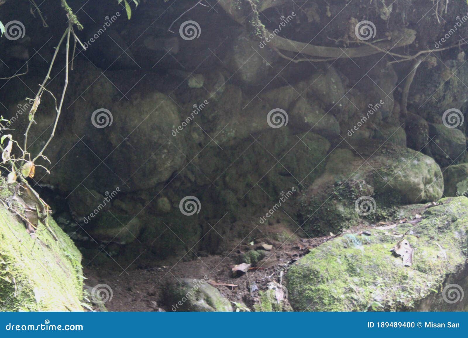 A Big Rock On The Side Of A Hill With Blurry Foggy Mountain Background ...