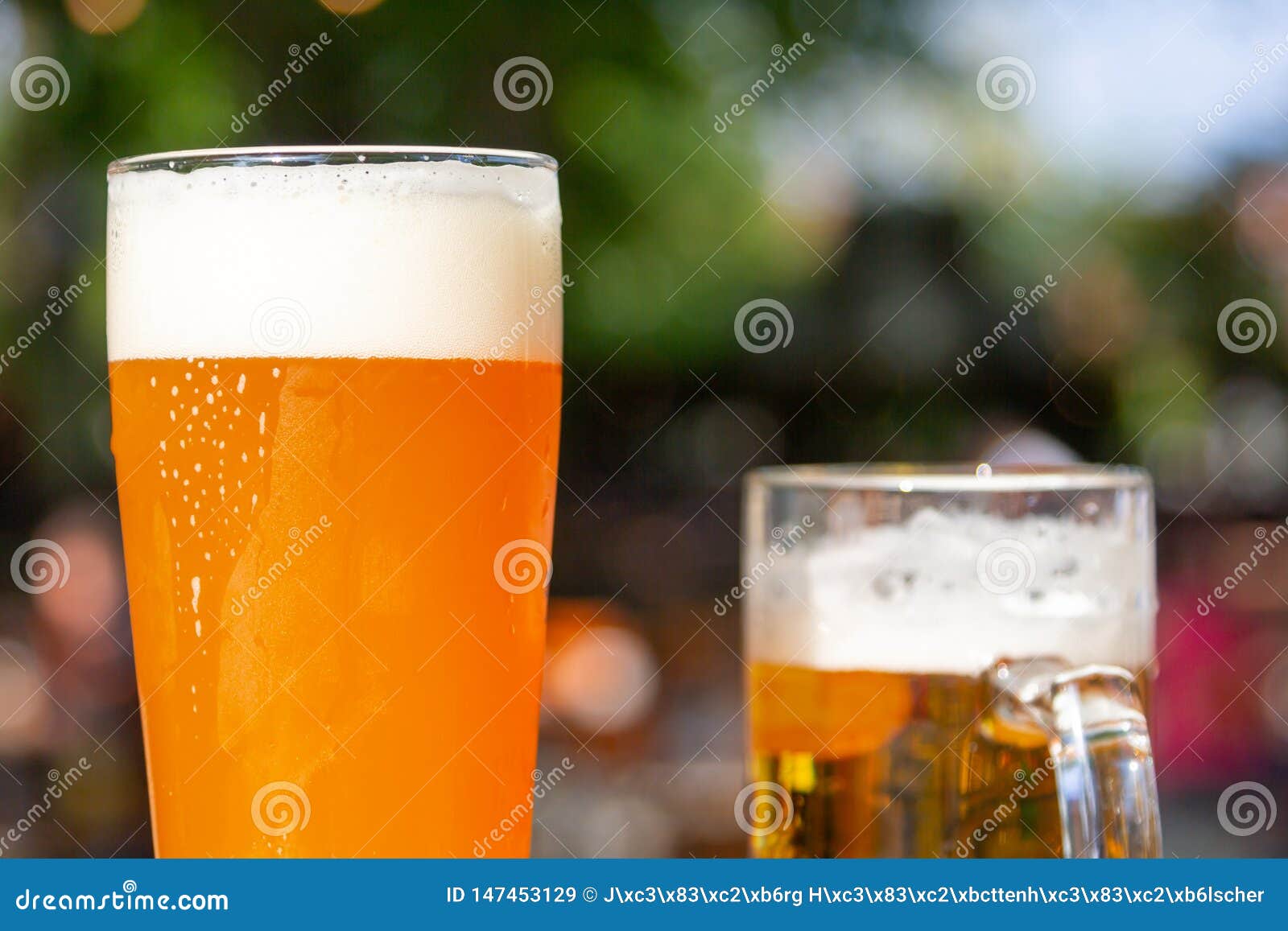 A Wheat Beer and a Pils are Standing on a Table in a Beer Garden Stock ...