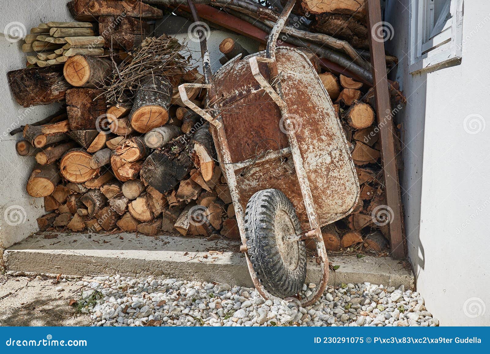 Wheel Barrow in the Garden by the Pile of Logs Stock Image - Image of ...