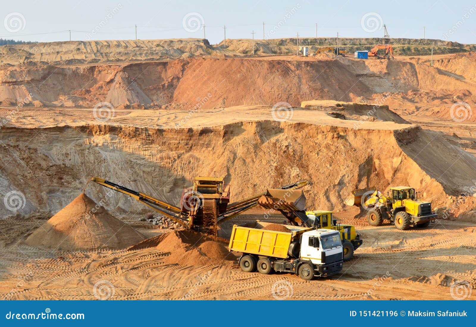 Wheel Front-end Loader Unloading Sand into Heavy Dump Truck. Crushing ...