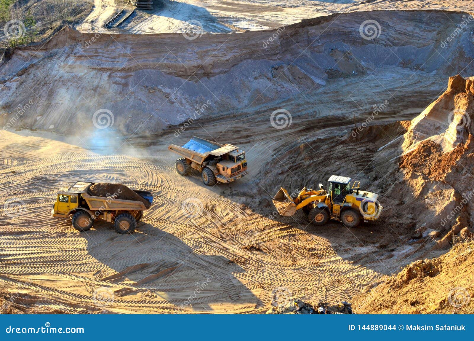 Wheel Front-end Loader Unloading Sand into Heavy Dump Truck at the ...