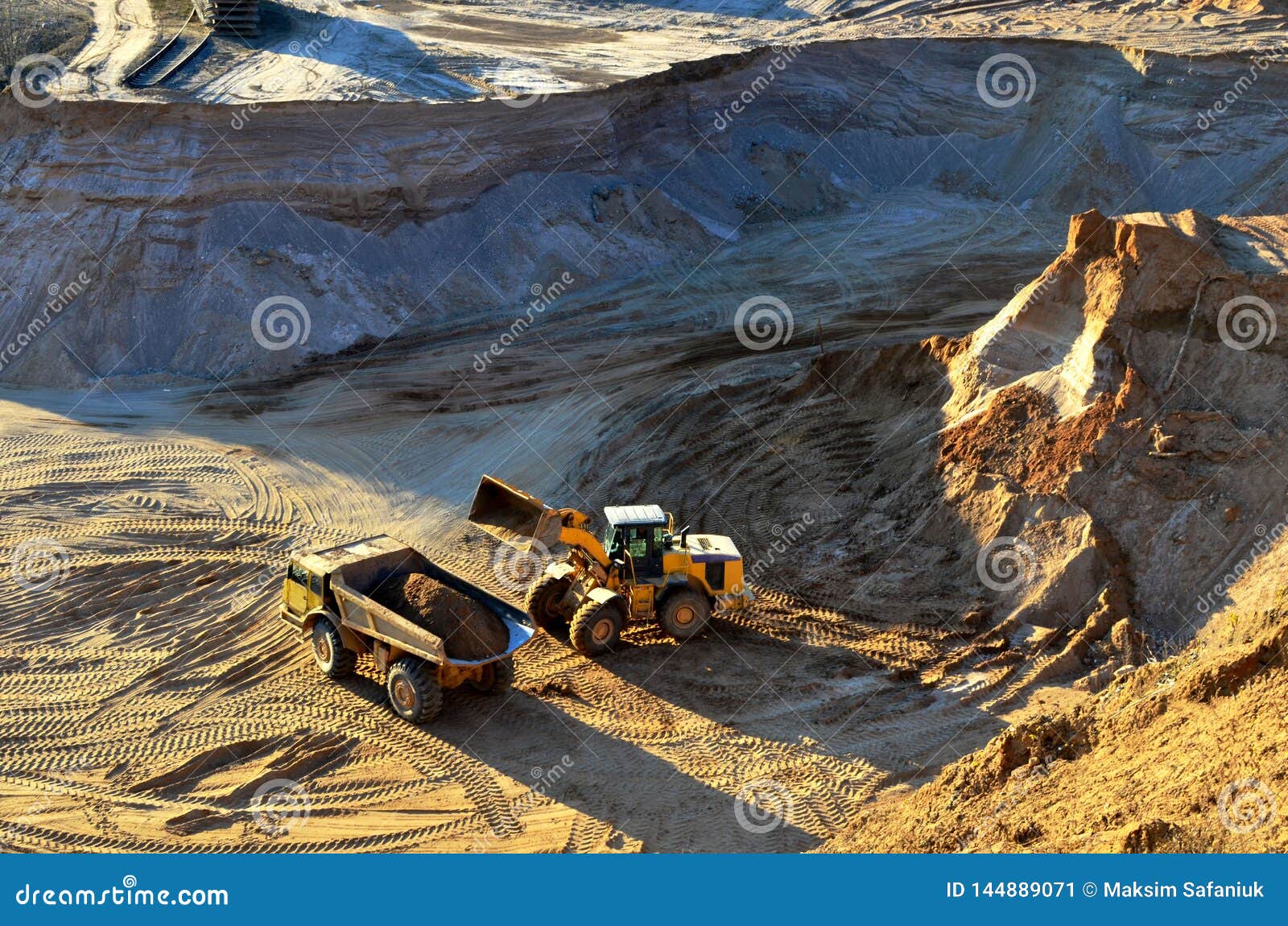 Wheel Front-end Loader Unloading Sand into Heavy Dump Truck at the ...