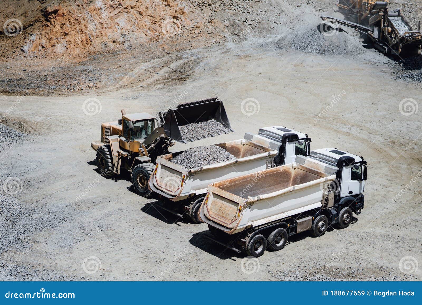 Wheel Loader Working on Construction Site and Loading Dumper Trucks ...