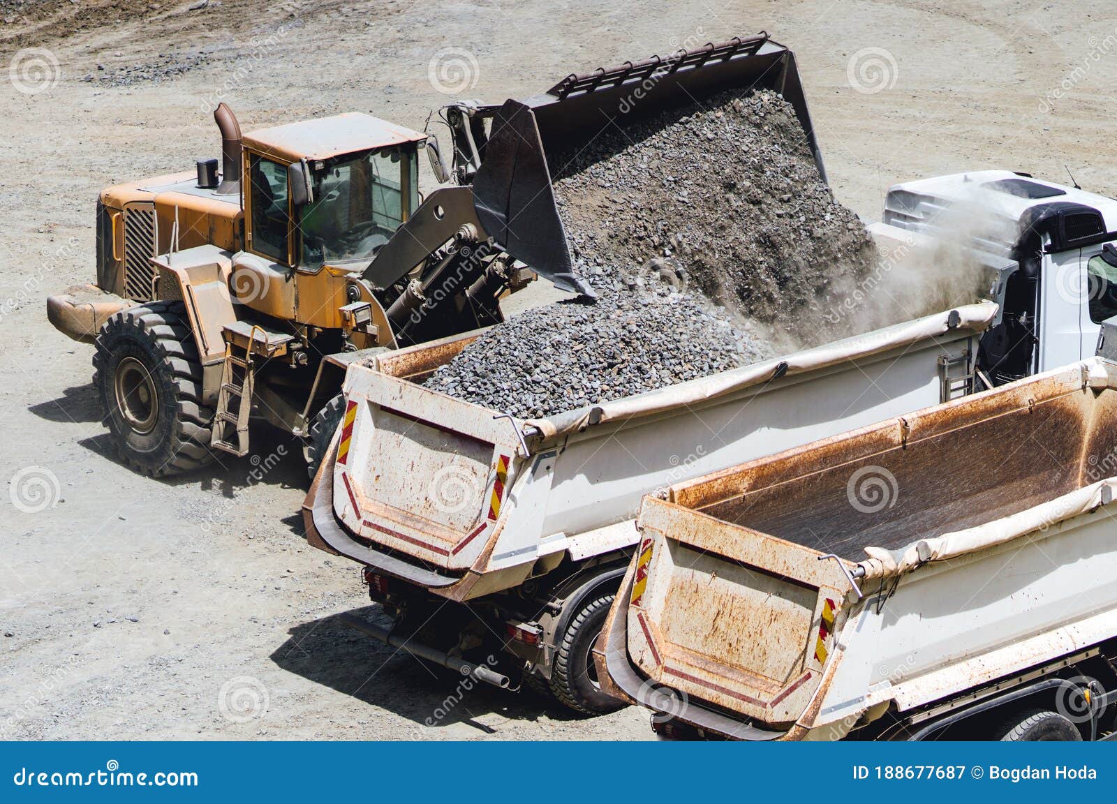 Wheel Loader Working on Construction Site and Loading Gravel on Dumper ...