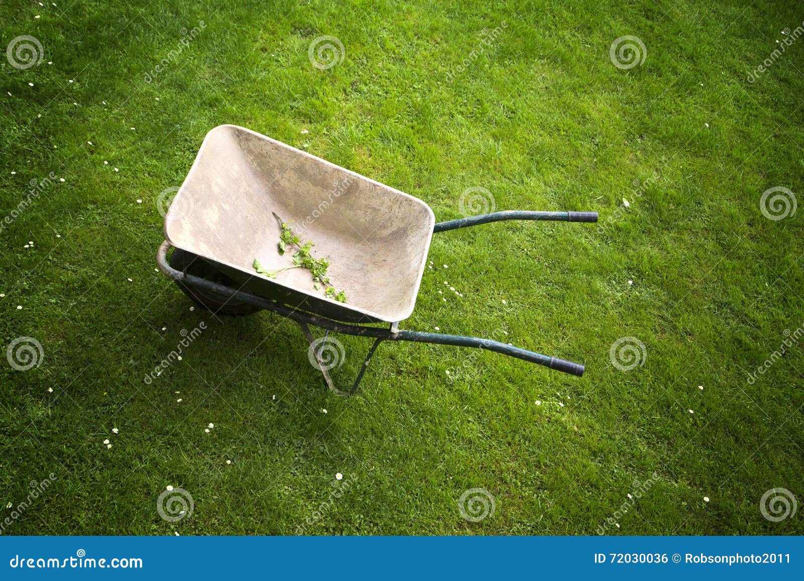 Wheelbarrow on a Green Grass Field Background Stock Photo - Image of ...