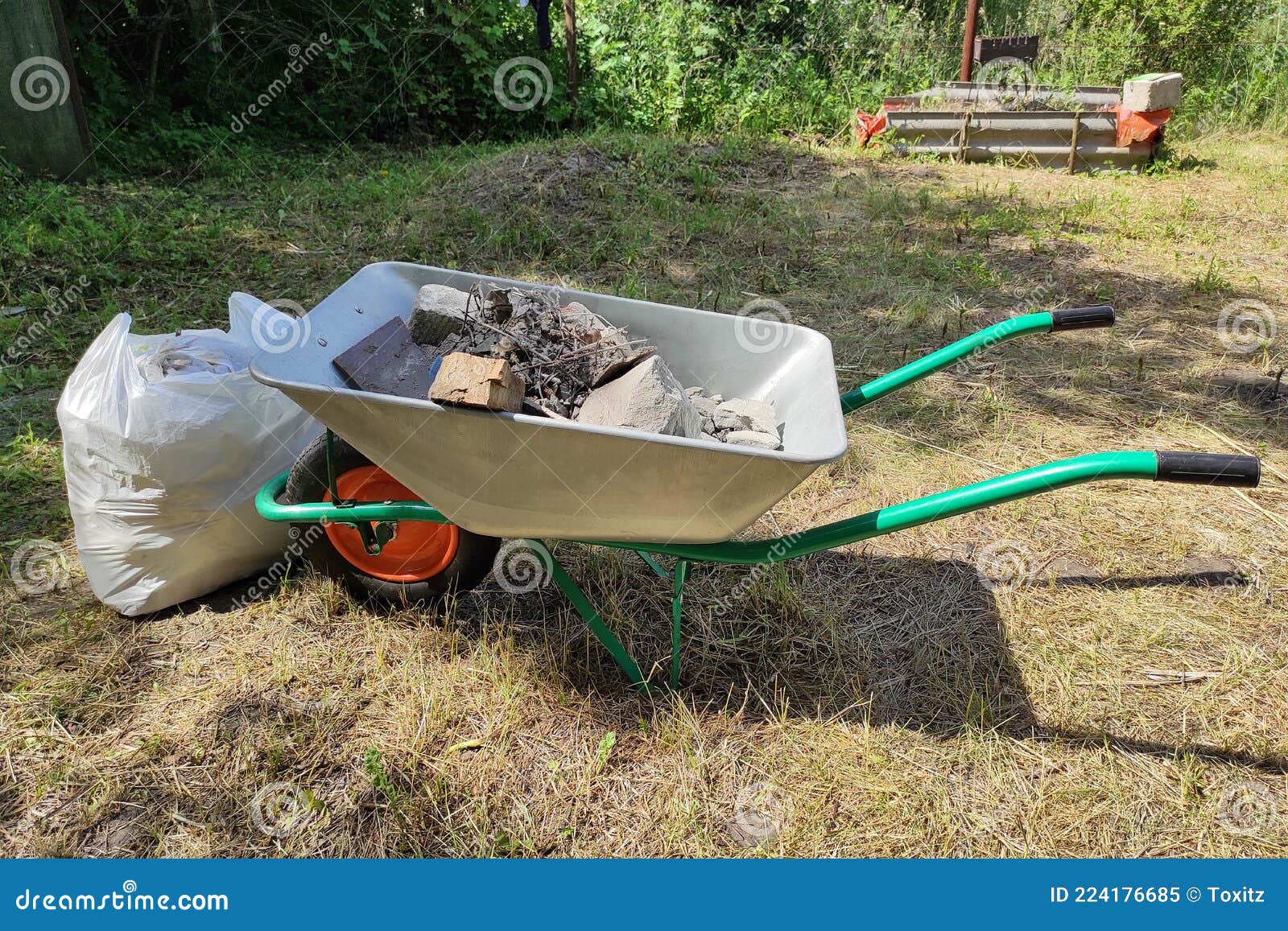 Wheelbarrow with Green Hadles with Construction Garbage Stock Image ...