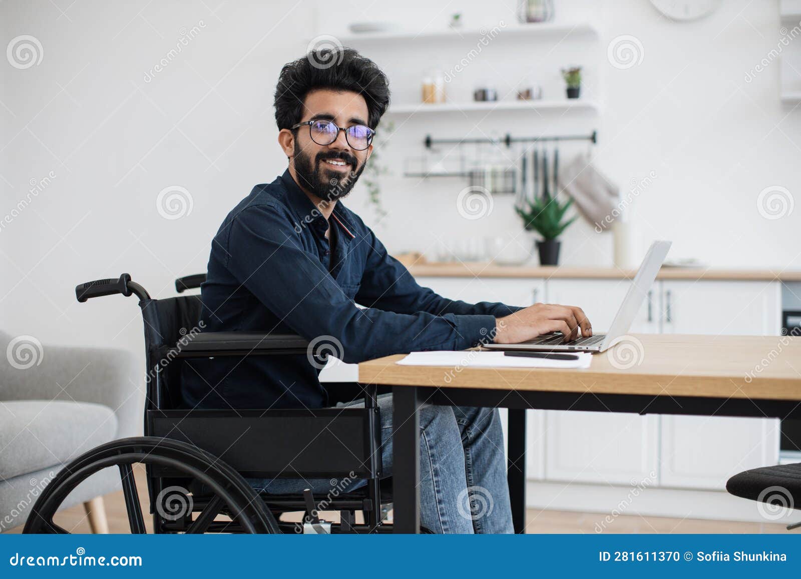 Wheelchair User Typing on Computer in Kitchen Interior Stock Photo ...