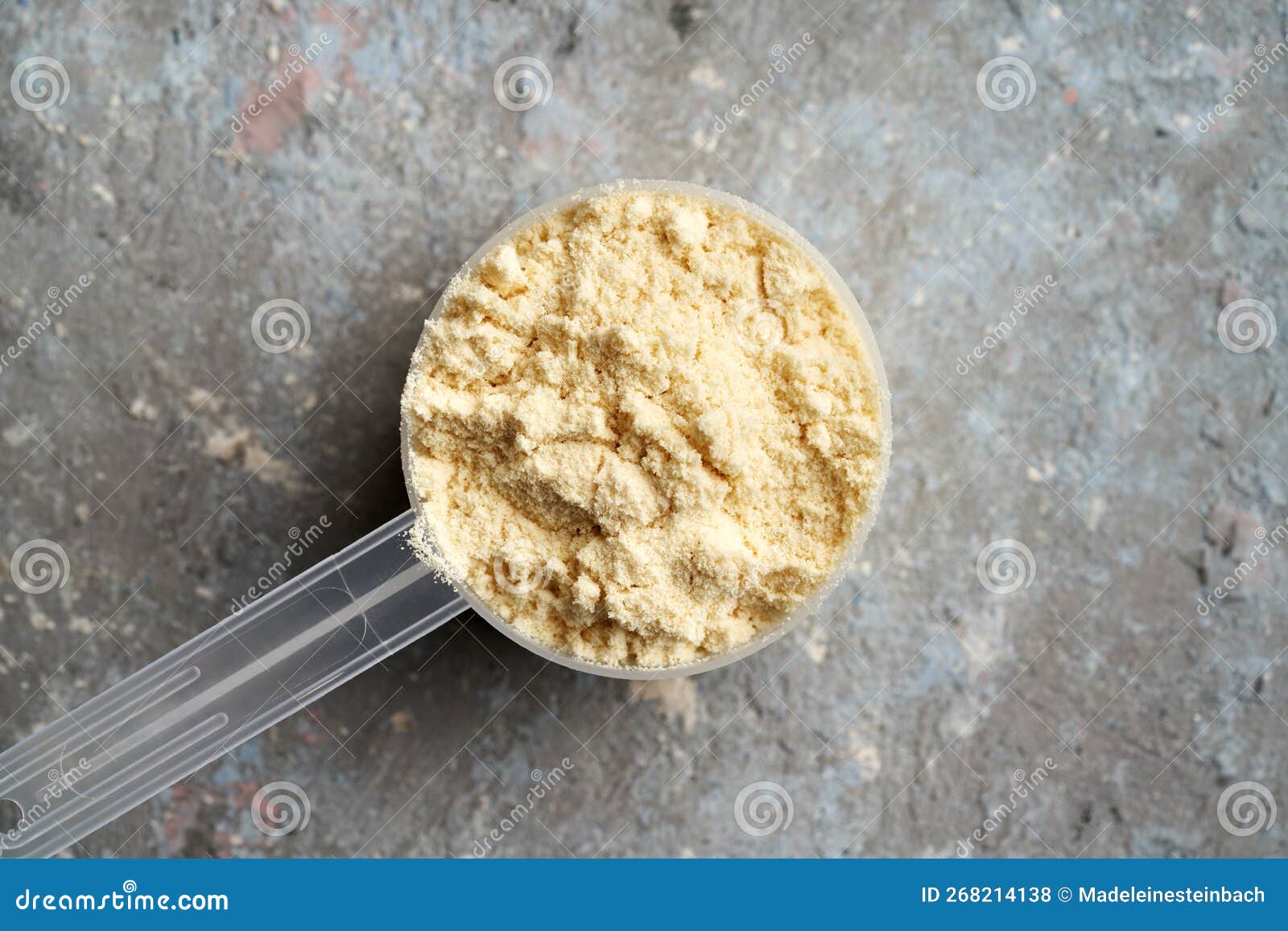 Whey Protein Powder in a Measuring Scoop on Textured Background Stock ...