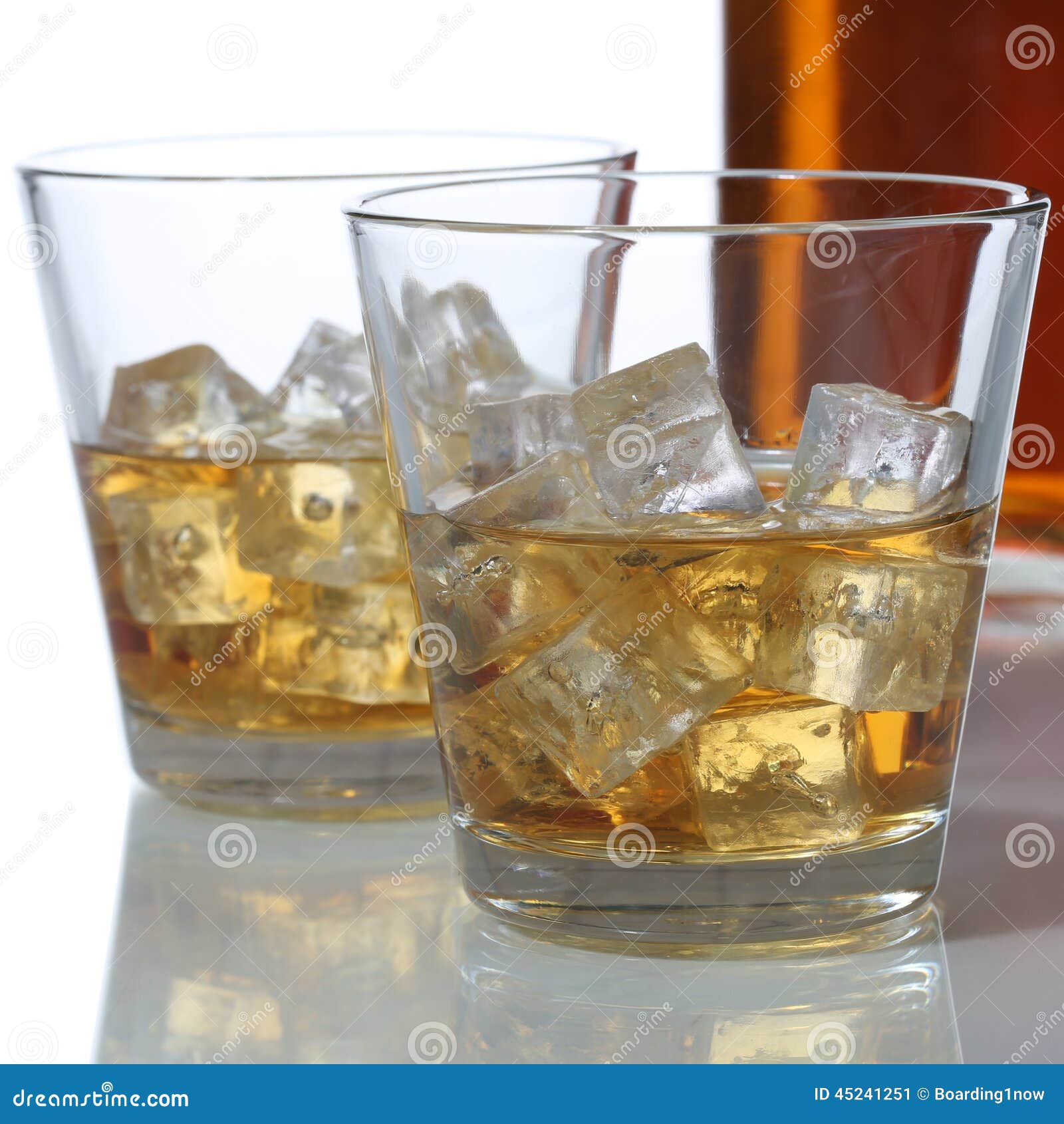 Whisky or Whiskey in a Glass and Bottle with Ice Cubes Stock Image ...