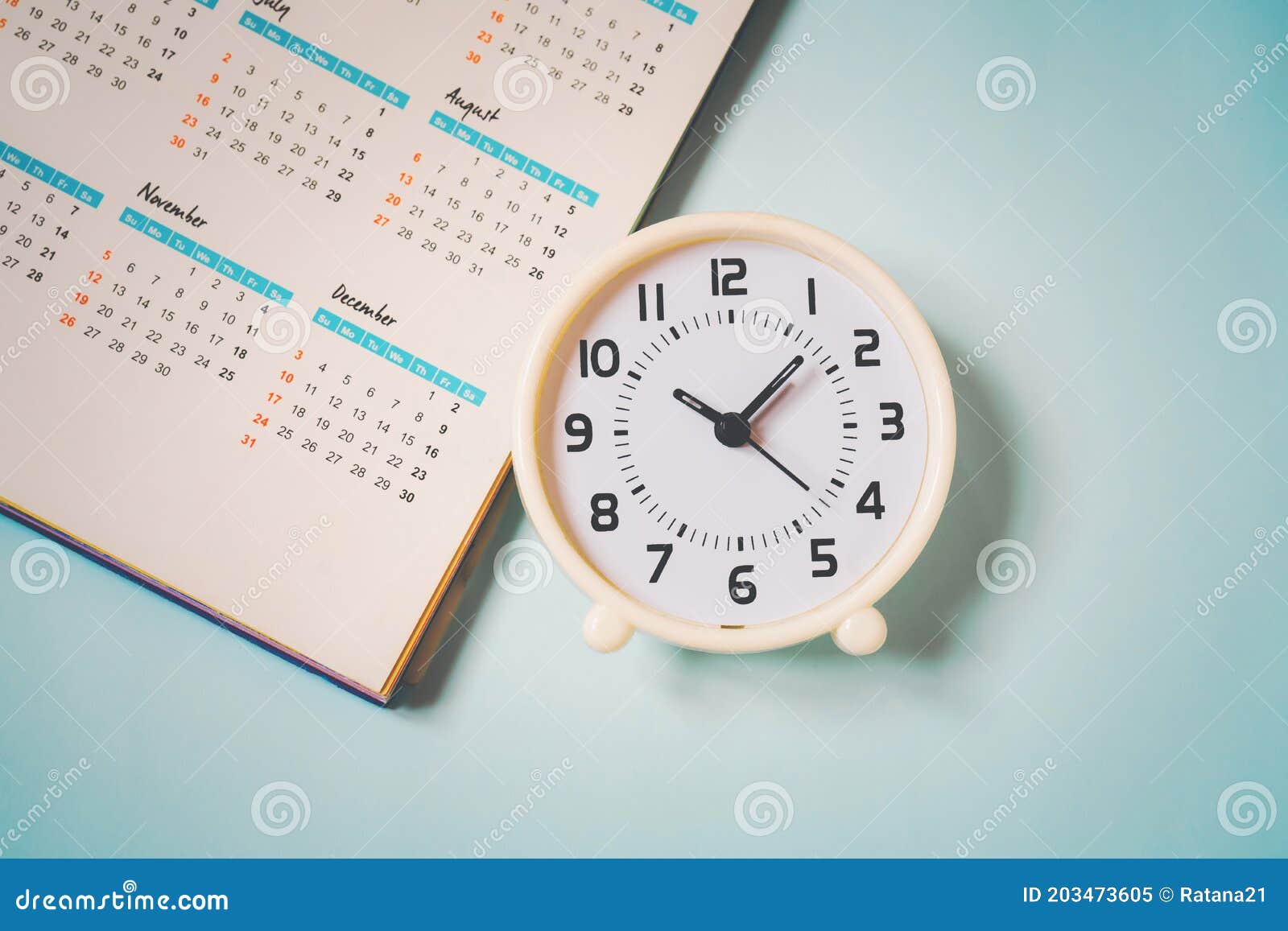 White Analog Clock on Yearly Calendar and Green Background , Top View ...