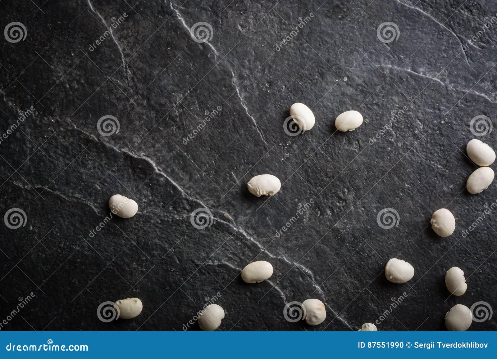 White Beans are Scattered Randomly on a Black Stone Table from Slate ...