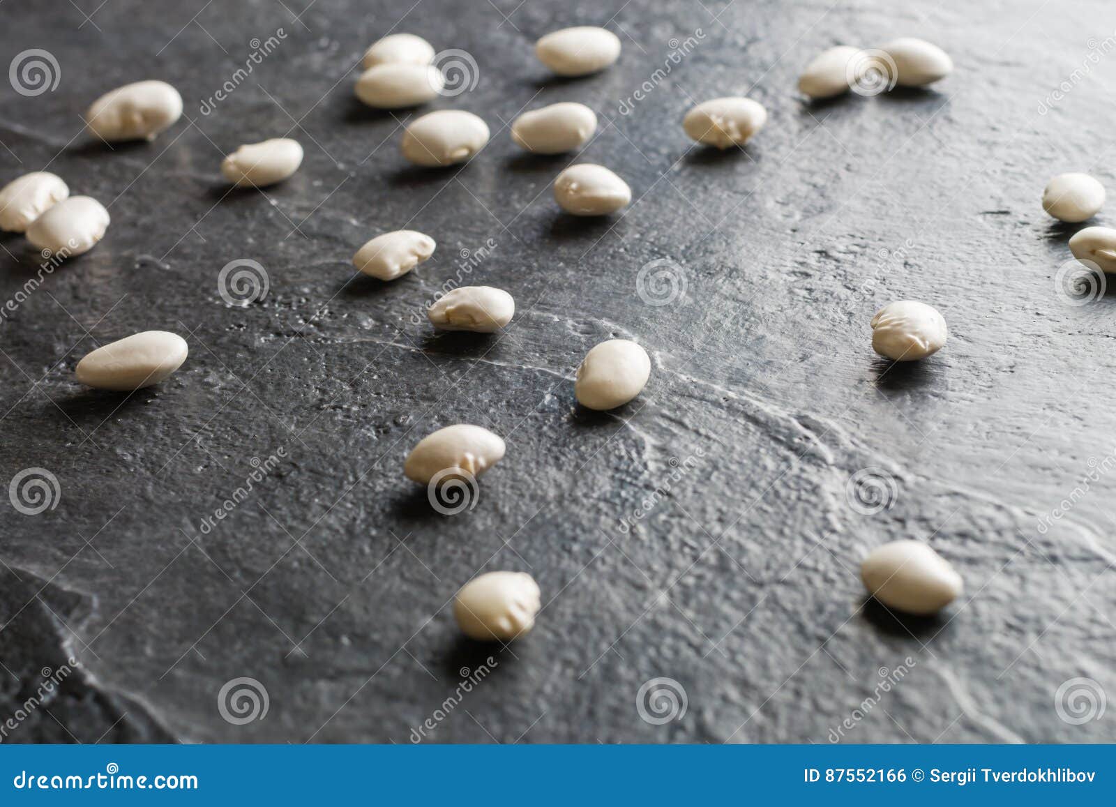 White Beans are Scattered Randomly on a Black Stone Table from Slate ...