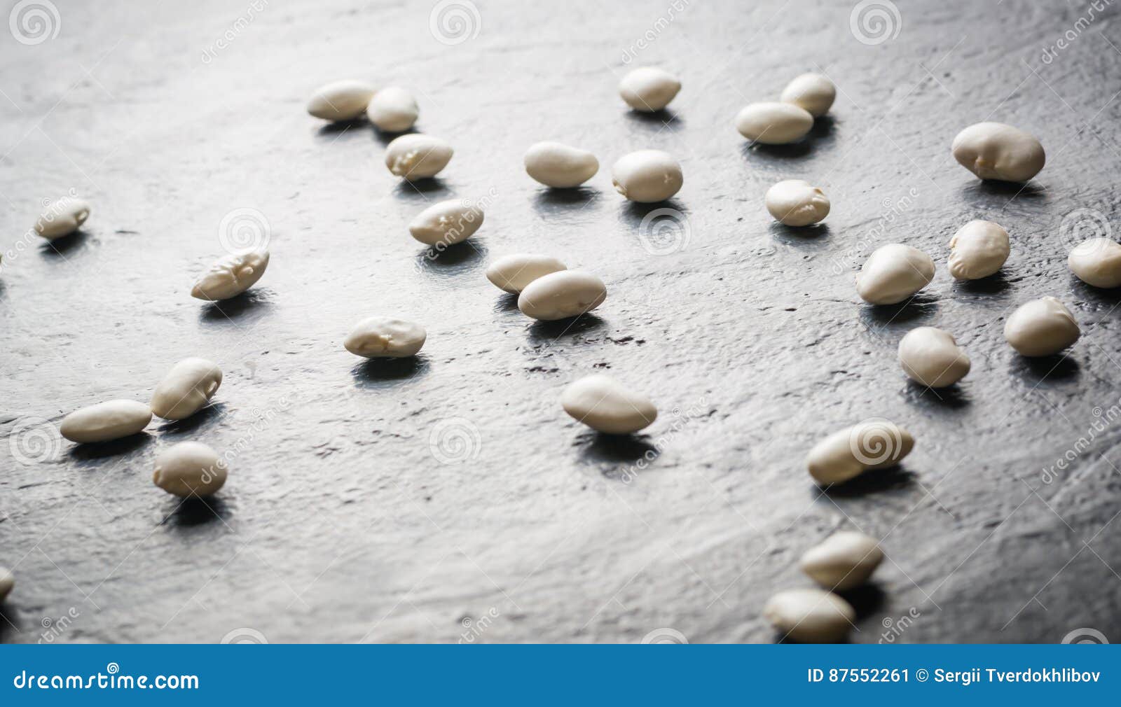 White Beans are Scattered Randomly on a Black Stone Table from Slate ...