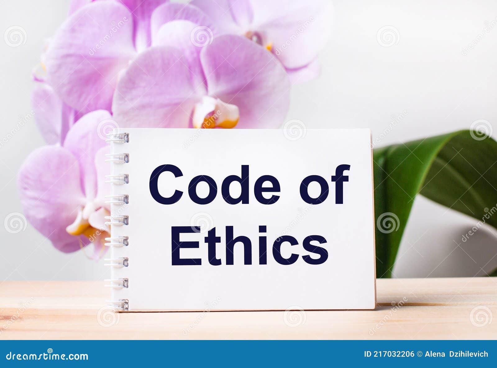White Blank Notebook with the Text CODE of ETHICS on the Table Against ...