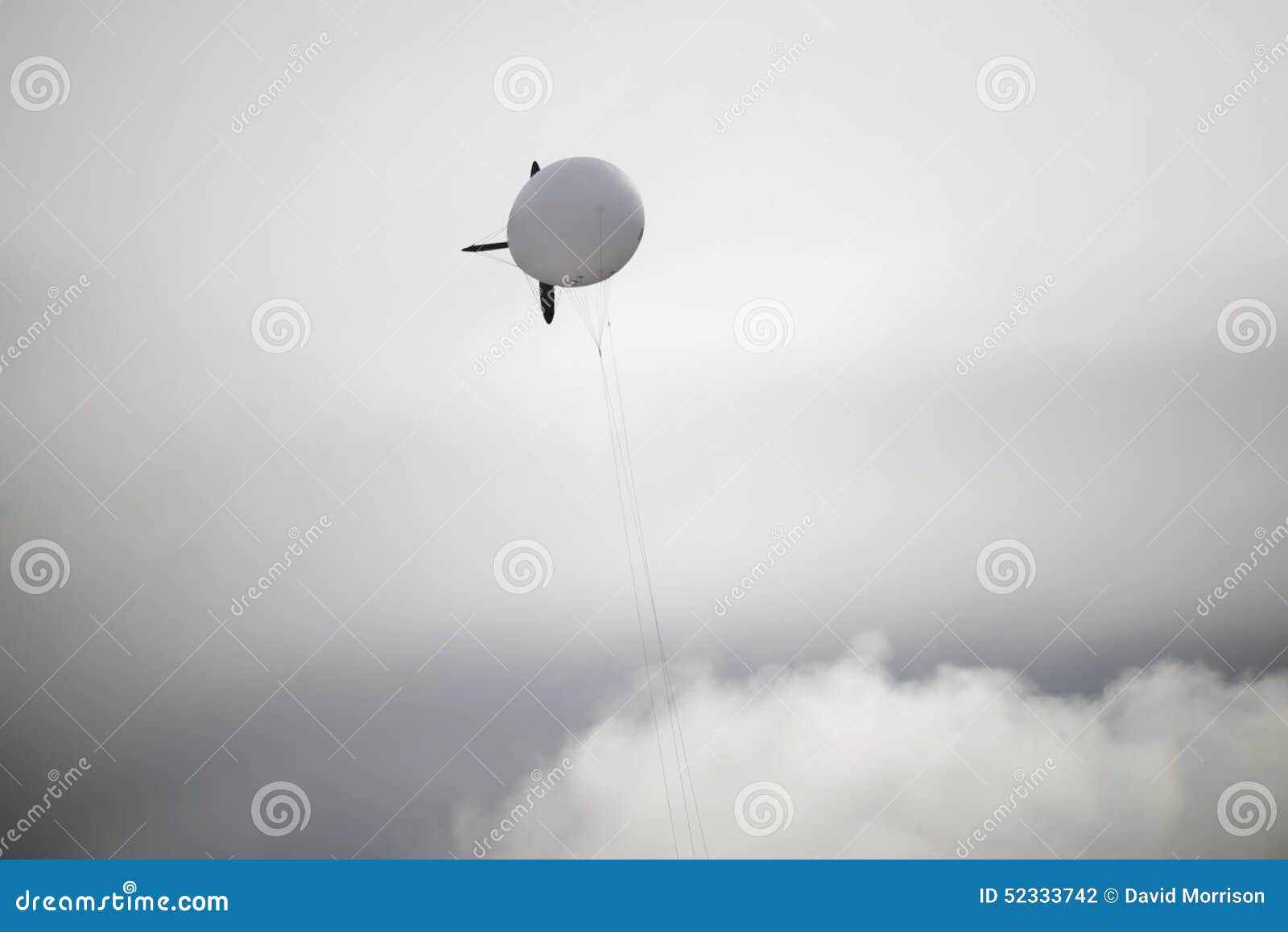 White Blimp High in the Grey Sky Stock Photo - Image of sign, advertise ...