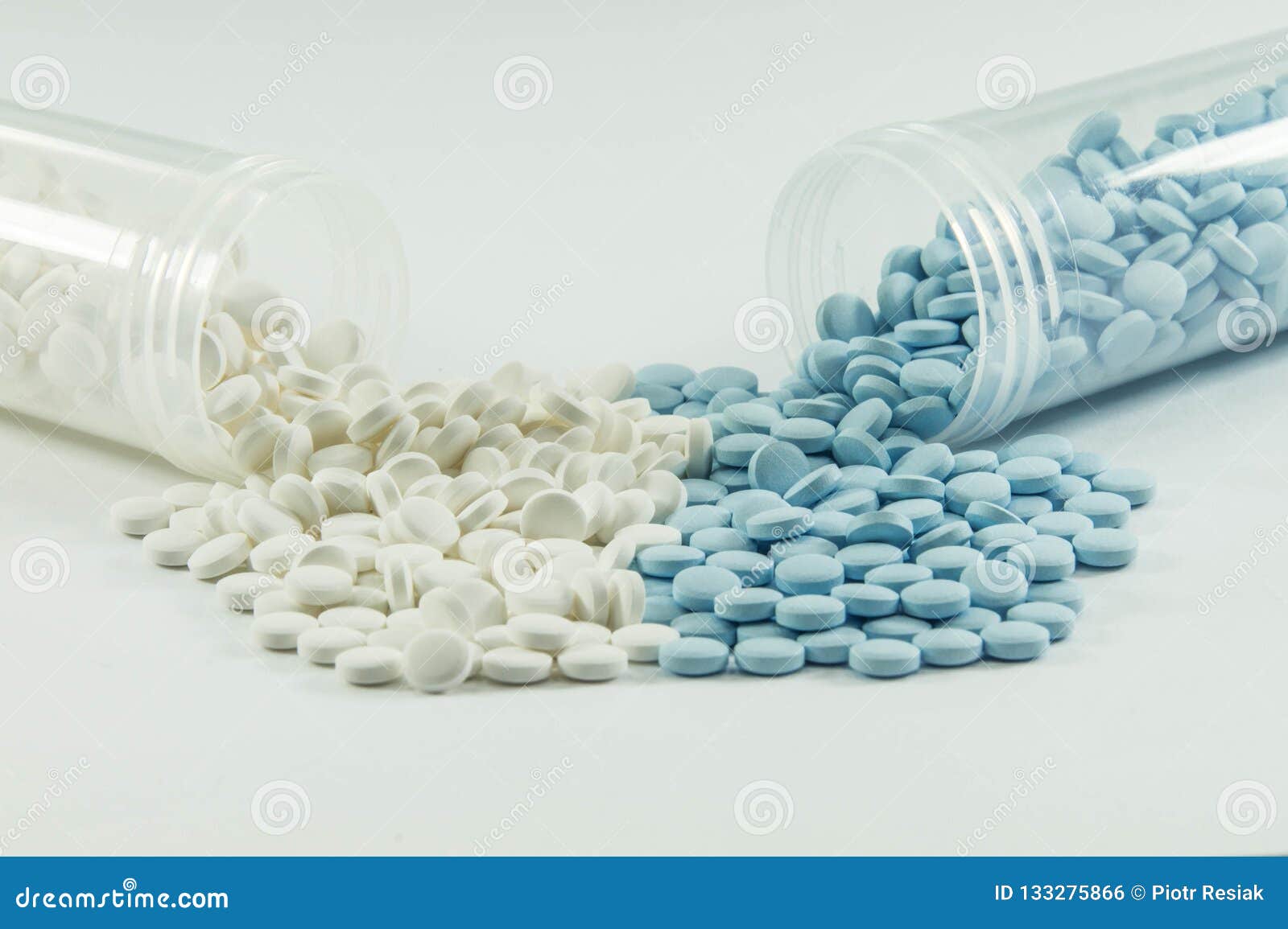 White and Blue Tablets Felt from Containers. Stock Photo - Image of ...
