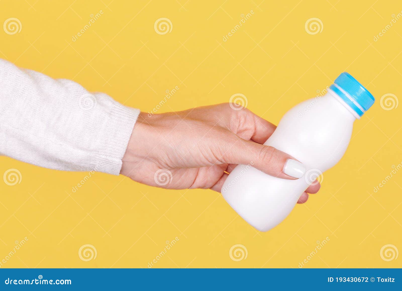 White Bottle with Kids Yogurt in Hand, Isolated on Yellow Background ...