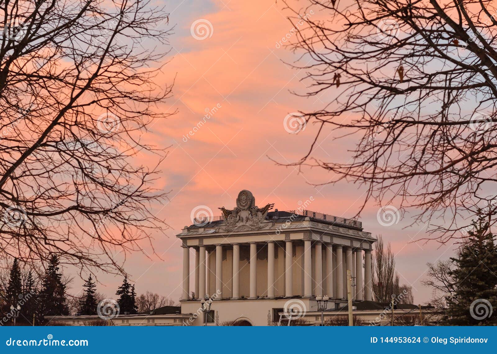 White Building with Columns between Tree Branches Against Stock Photo ...
