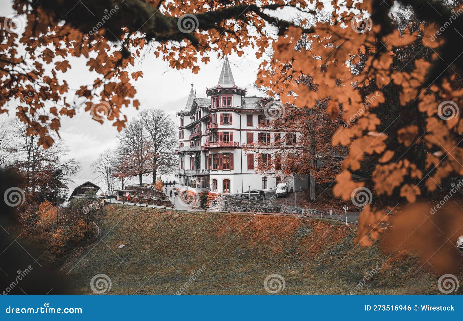 White Building with a Pointed Spire and an Array of Vibrant Red Foliage ...