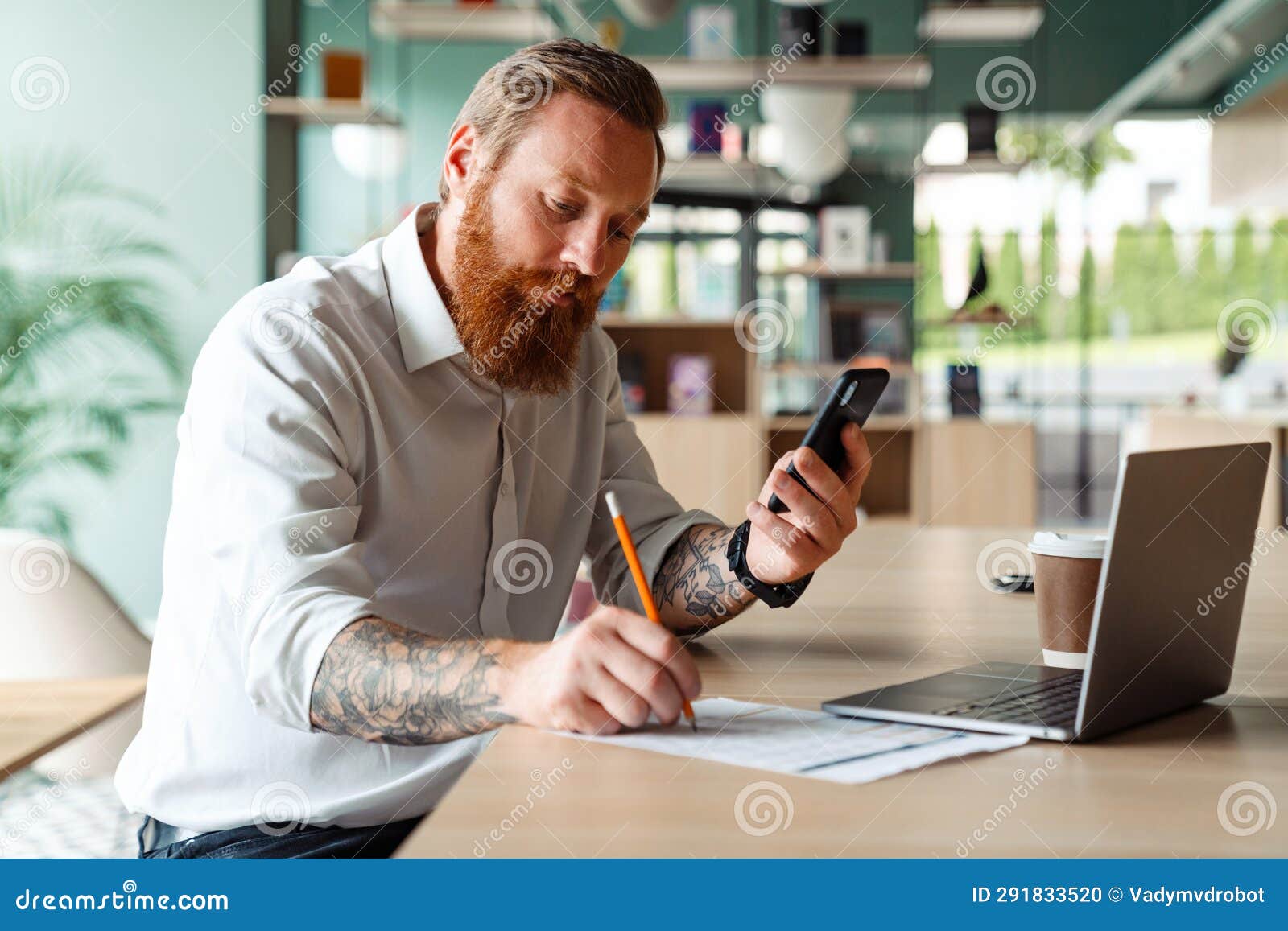 White Business Man Writing Down Notes while Working on Laptop in Office ...