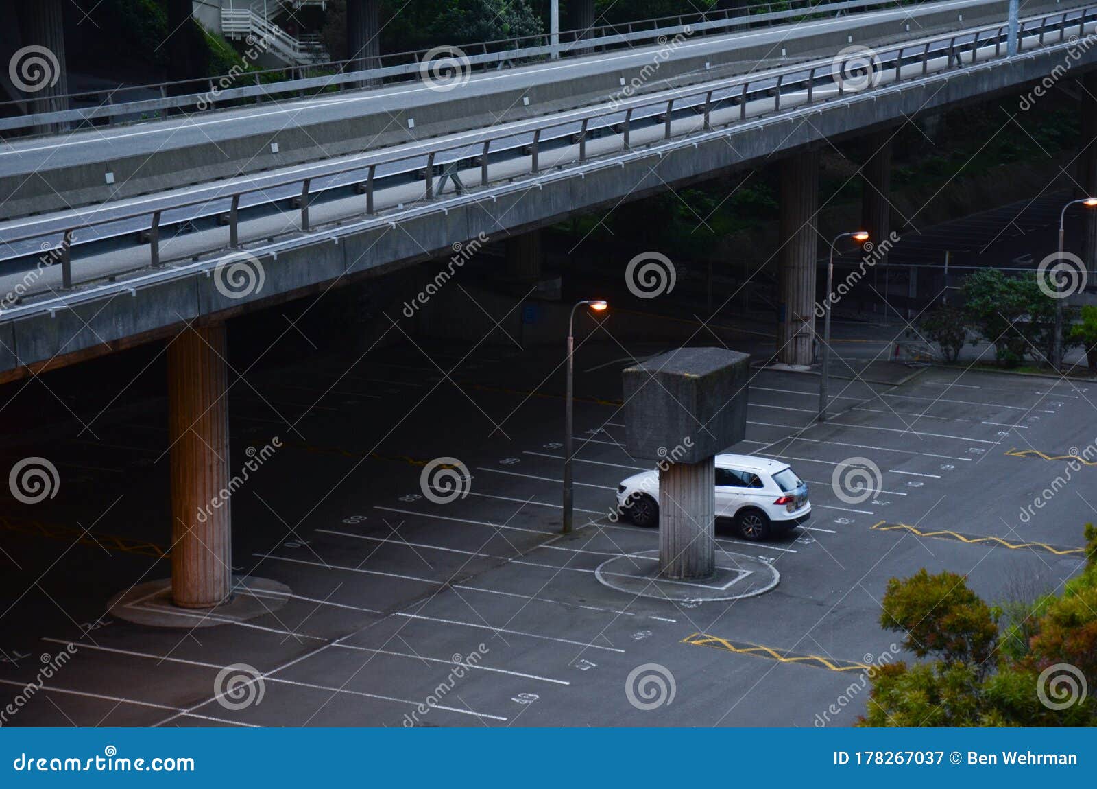 White Car Hiding Behind Concrete Pole in Parking Lot Stock Image ...