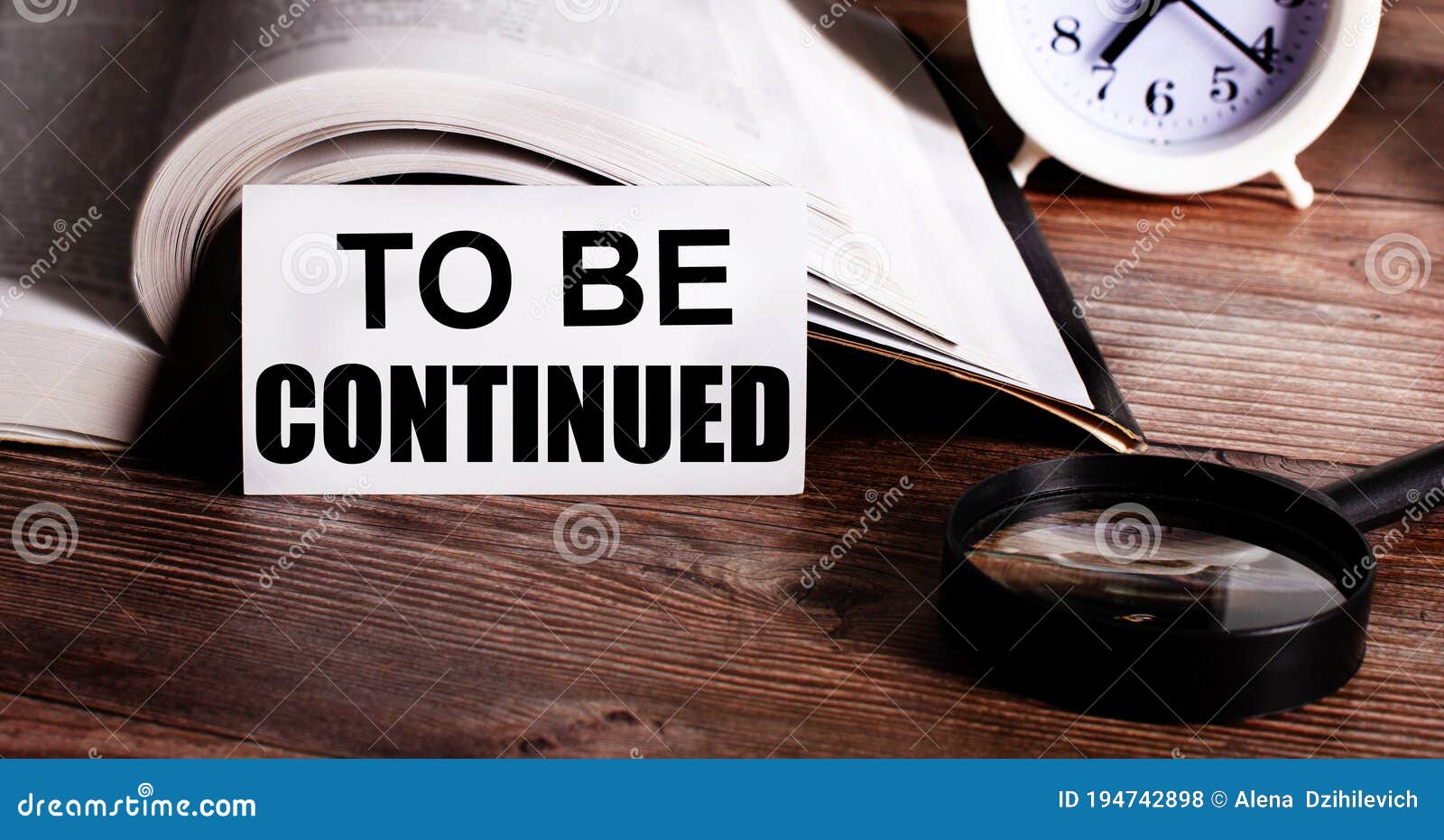 The White Card Next To the Open Book Says TO BE CONTINUED Stock Photo ...