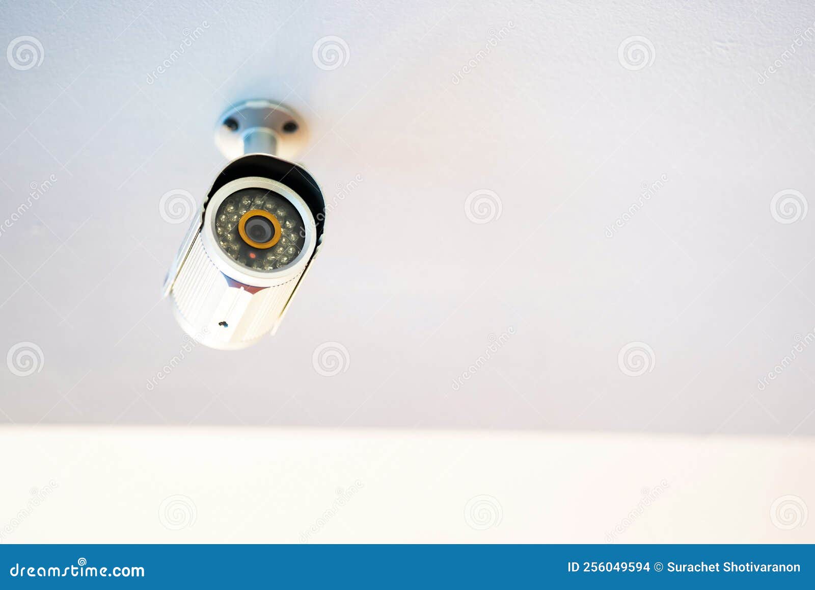 White CCTV with Orange Black Camera Len in the Centre Hanging from the ...